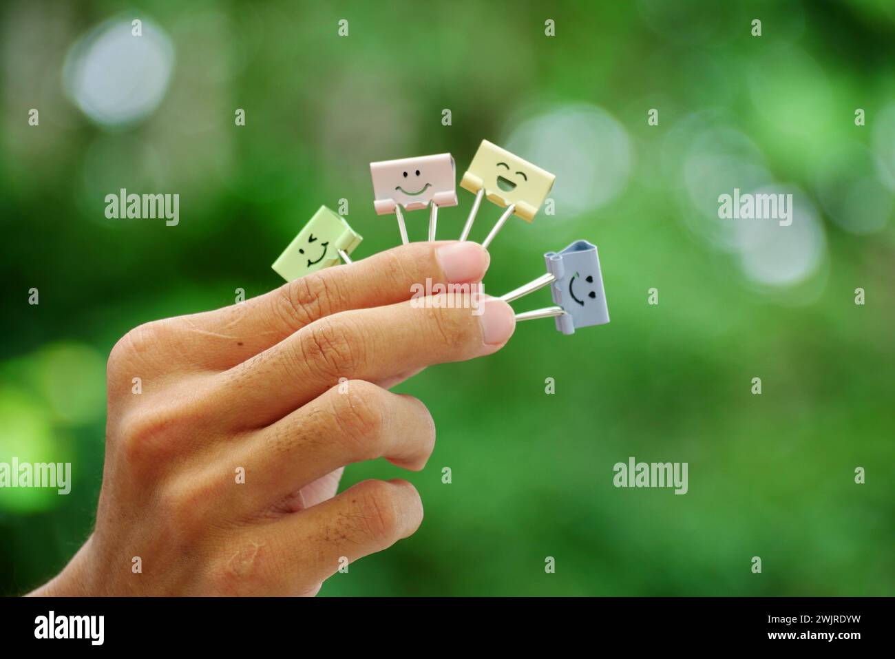 Happy emoticon paperclip on finger. Concept of positive thinking ...