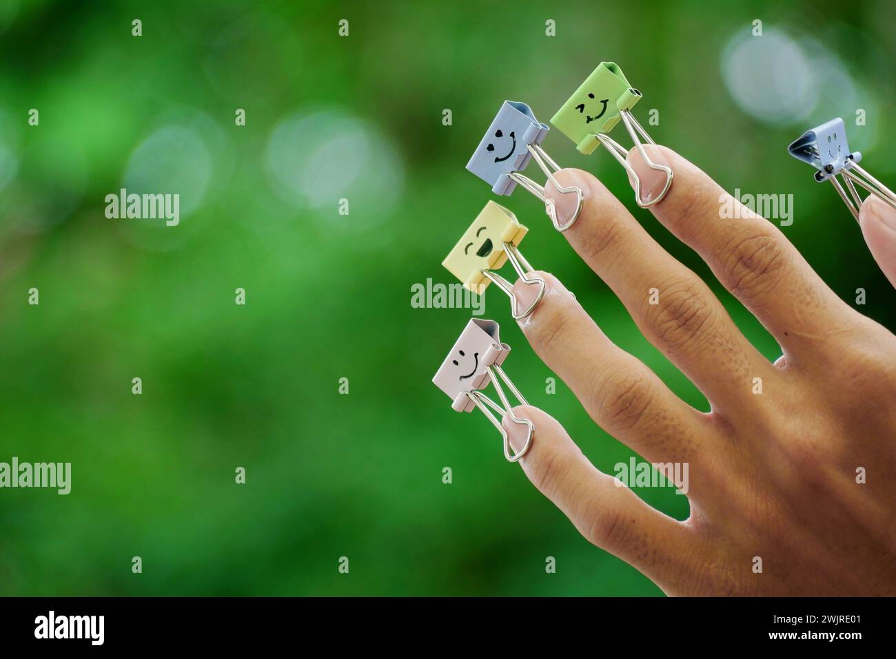 Happy emoticon paperclip on finger. Concept of positive thinking ...