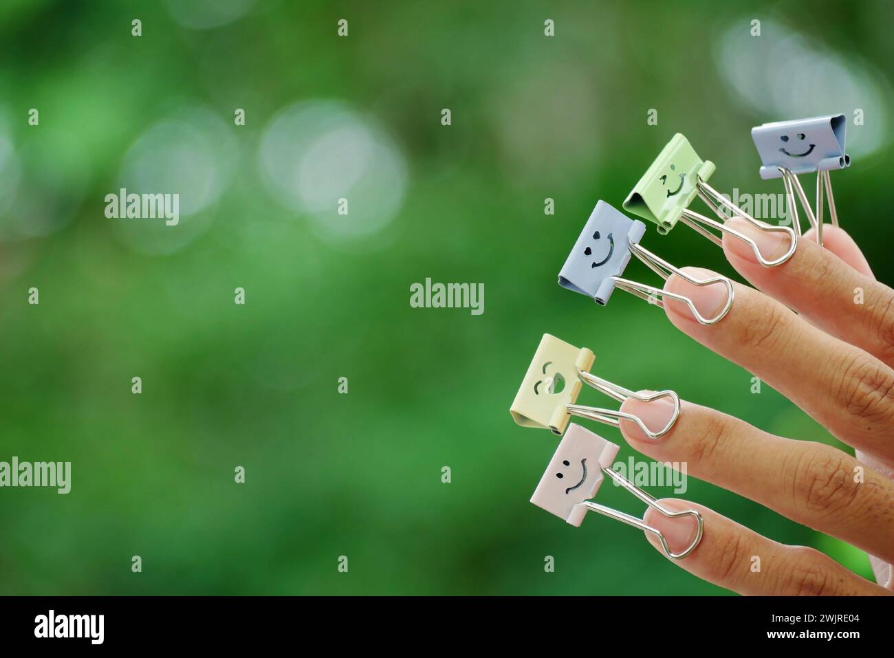 Happy emoticon paperclip on finger. Concept of positive thinking ...