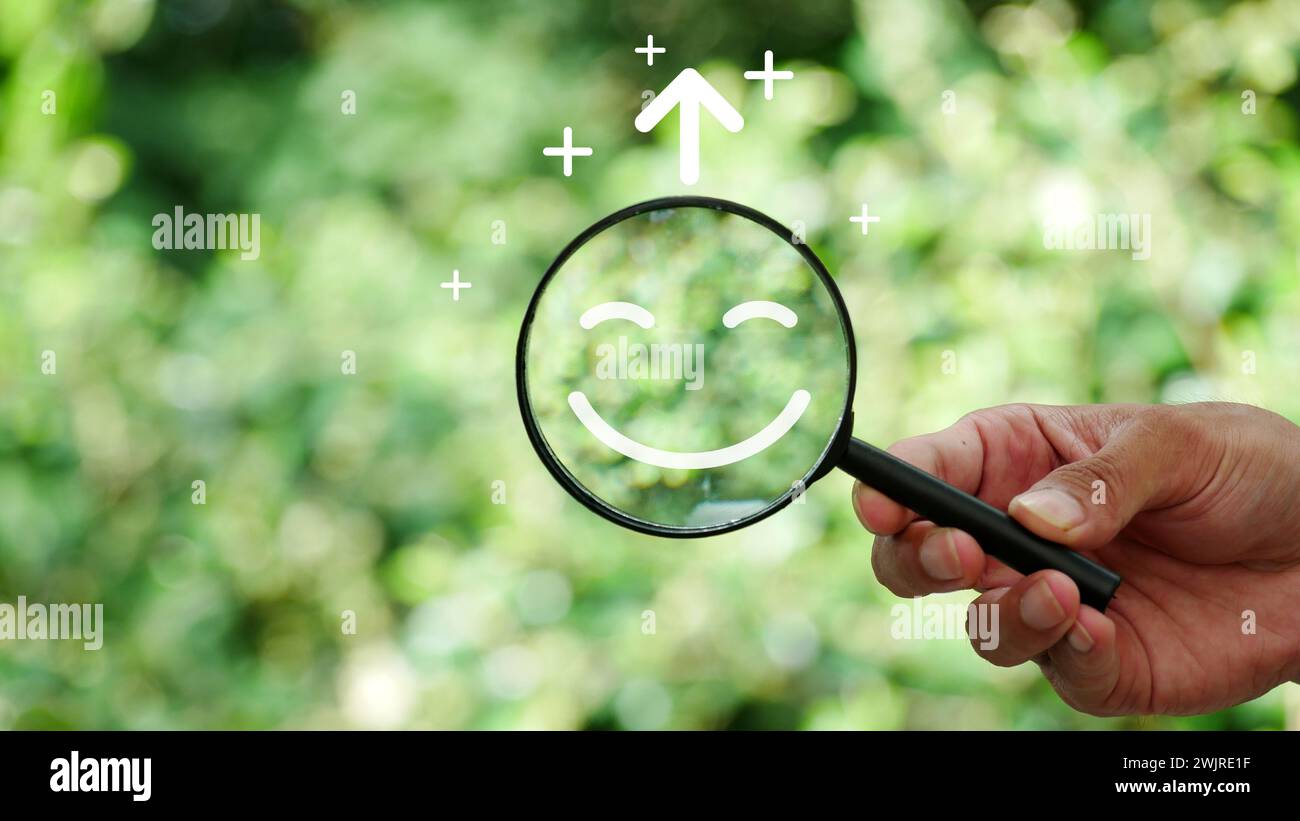 Hand holding a magnifying glass highlighting a happy smile. Concept of ...