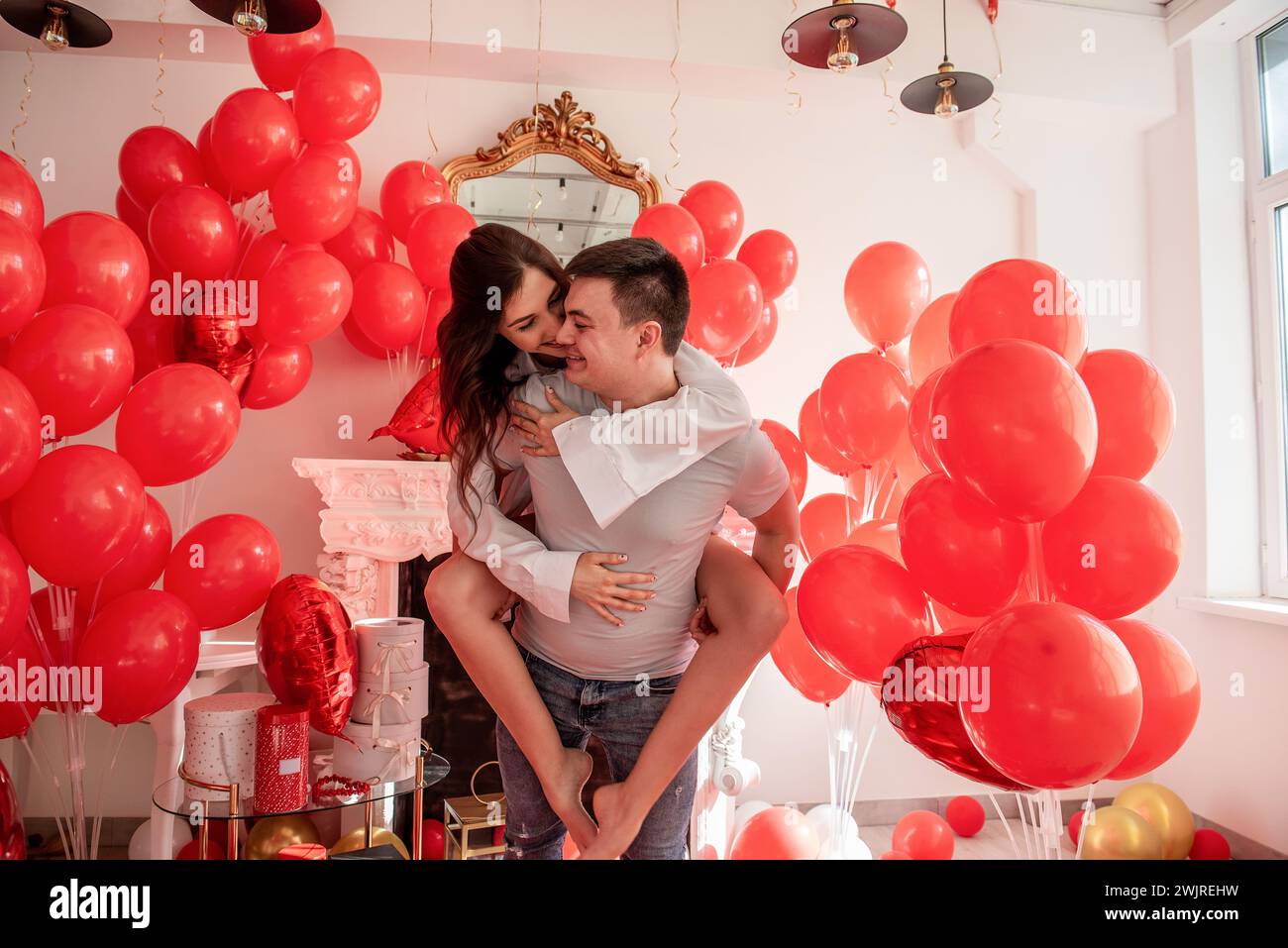 Playful, romantic moment between crazy couple near red balloons in ...