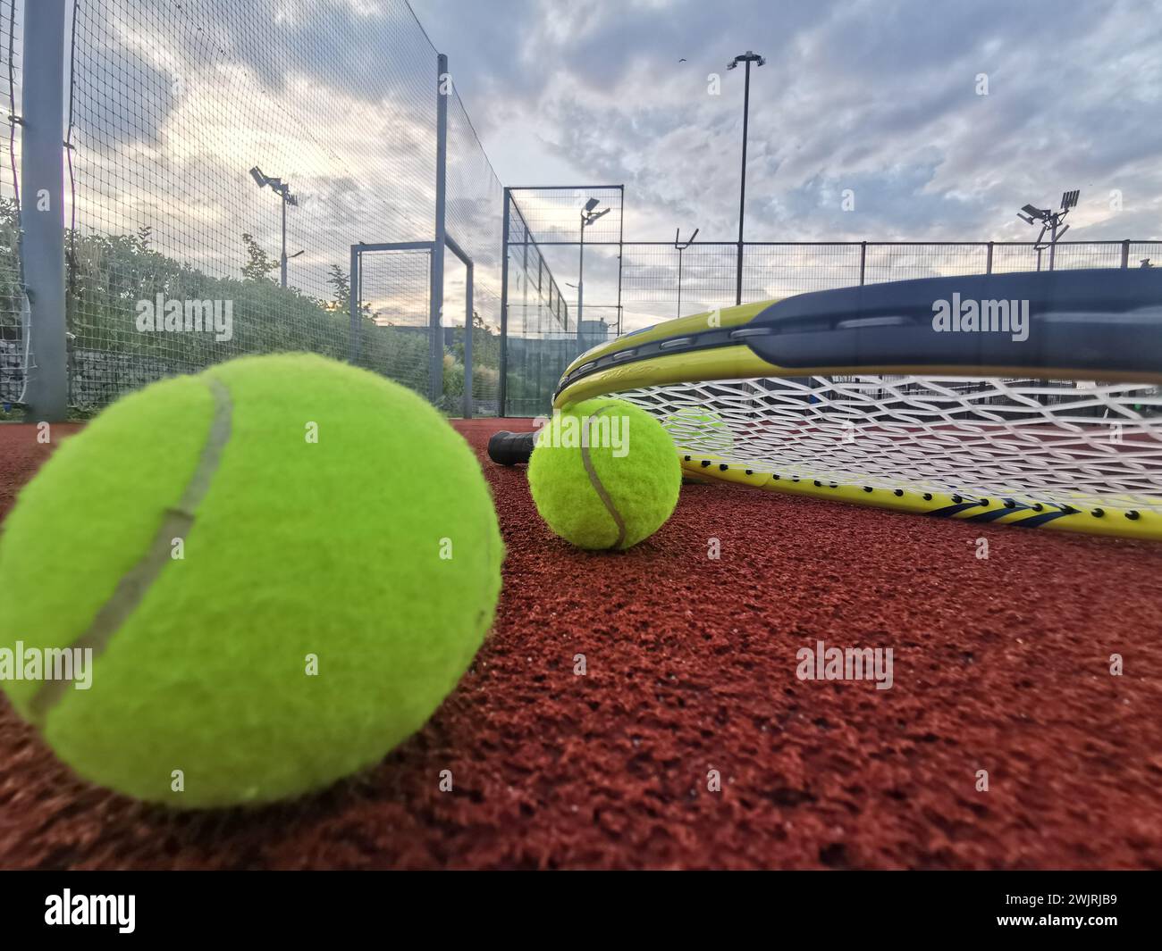 yellow tennis balls and racquet on hard tennis court surface, top view ...