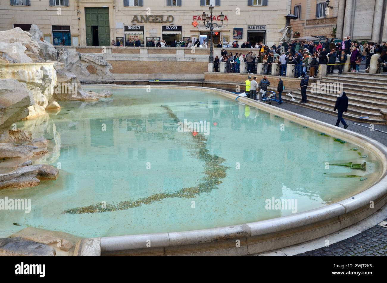 men collecting the money thrown into the trevi fountain rome capital of ...