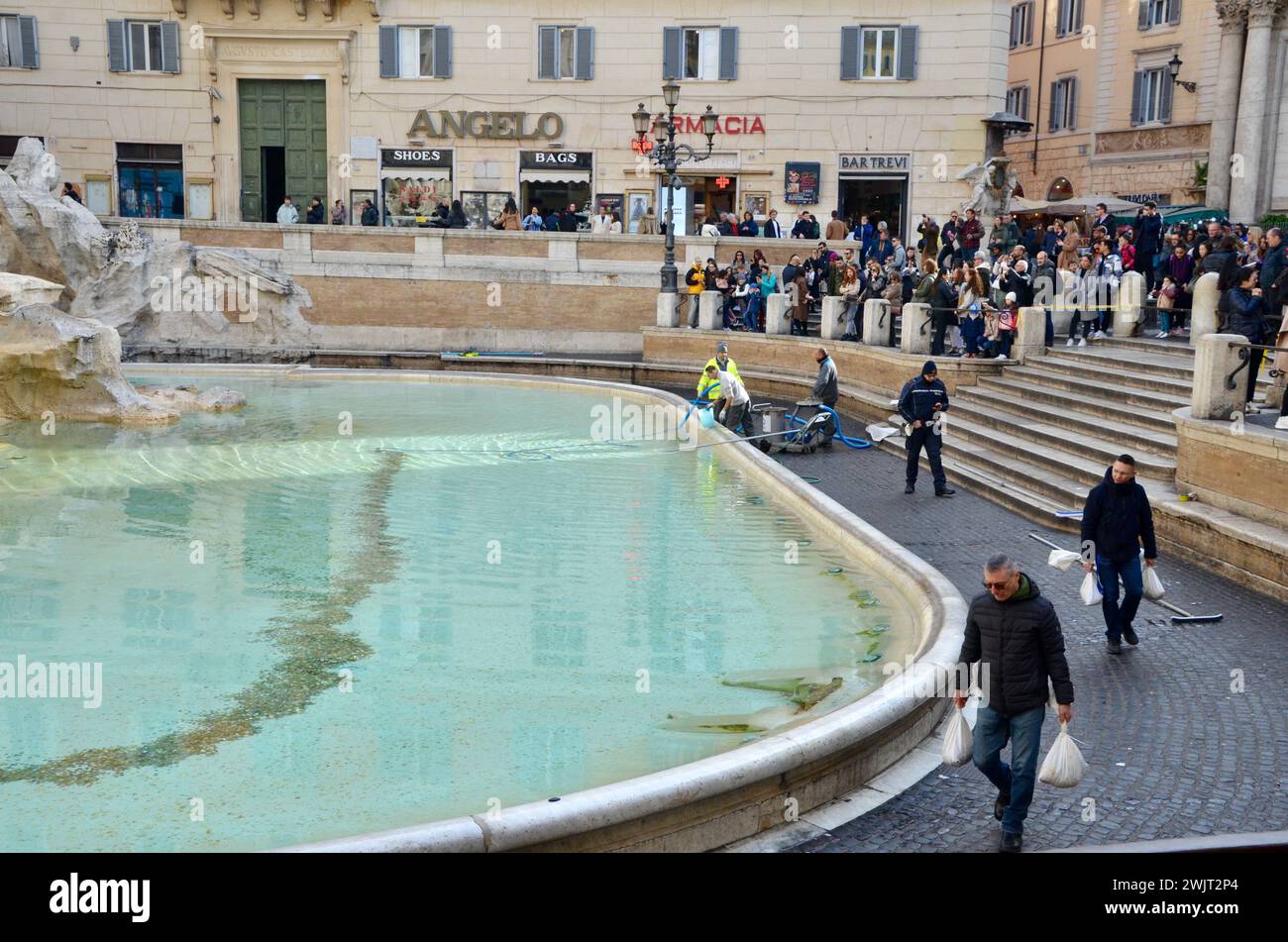 men collecting the money thrown into the trevi fountain rome capital of ...
