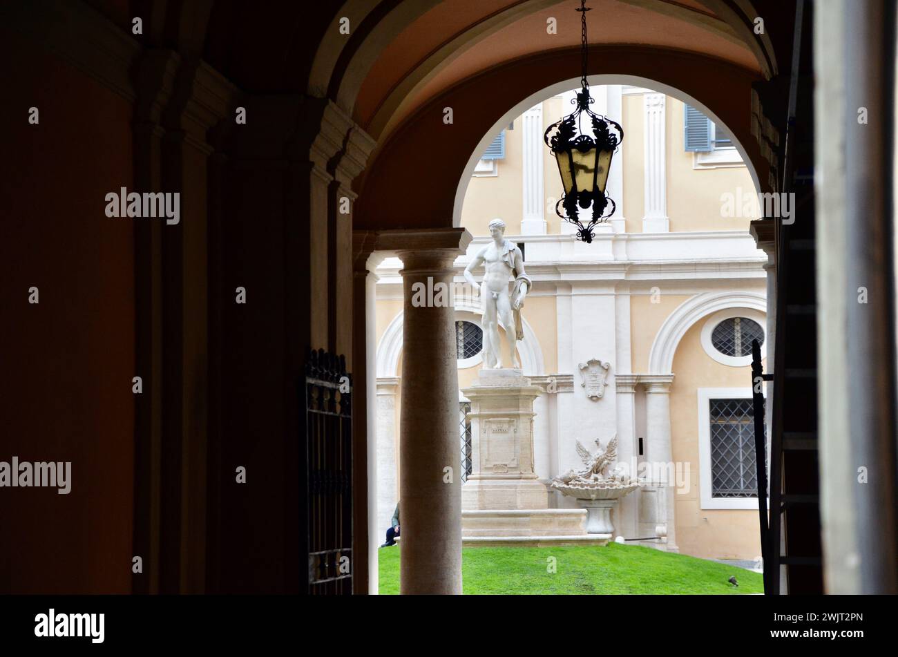 a roman statue on a plinth in a courtyard of a housing block in rome ...