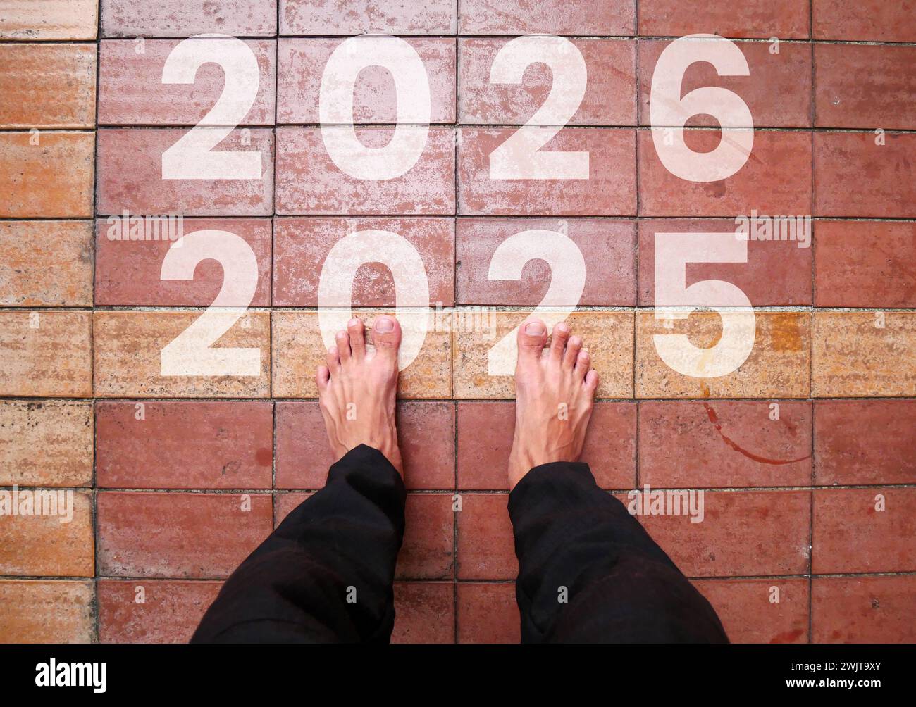 The text 2025 is written on the brick road and the male runner prepares ...