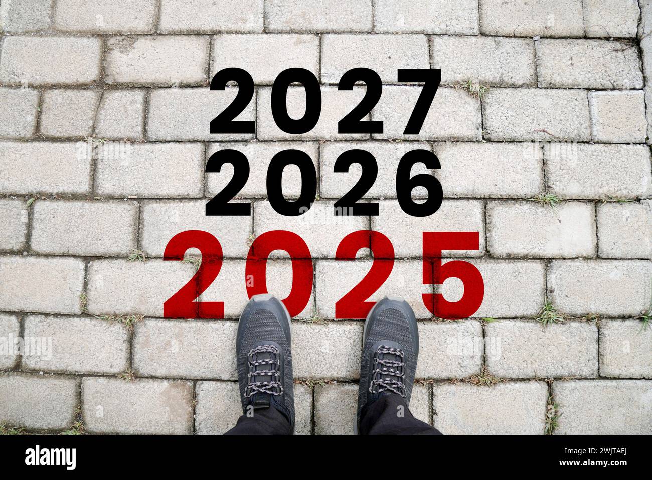 The text 2025 is written on the brick road and the male runner prepares ...