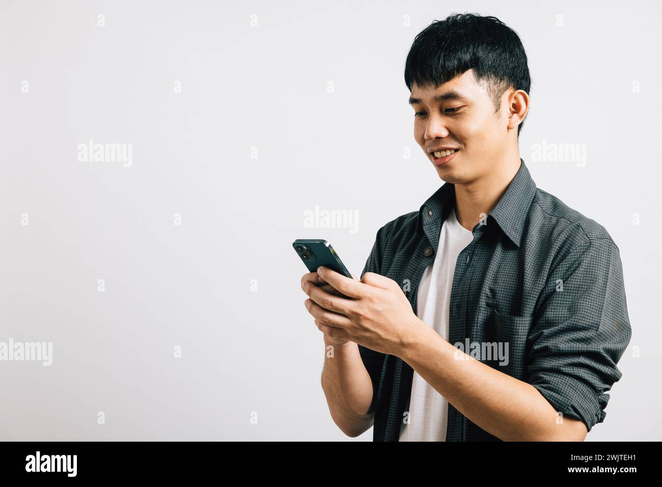 Asian teenager, filled with excitement, types a text message on his ...