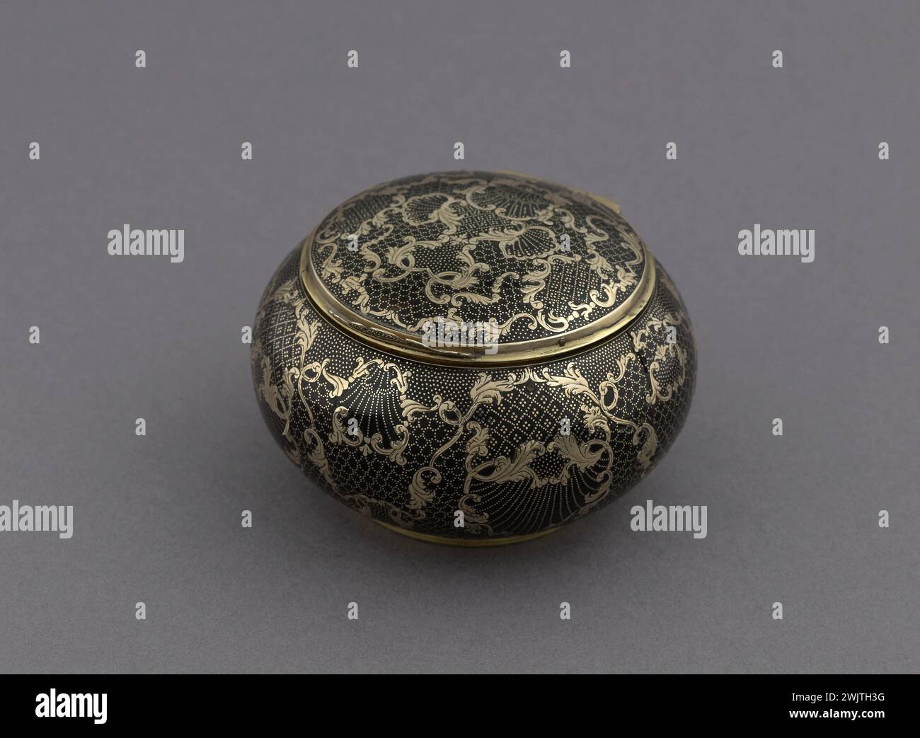 Flattened spherical box, in gold embroidered scales. On the reverse of ...