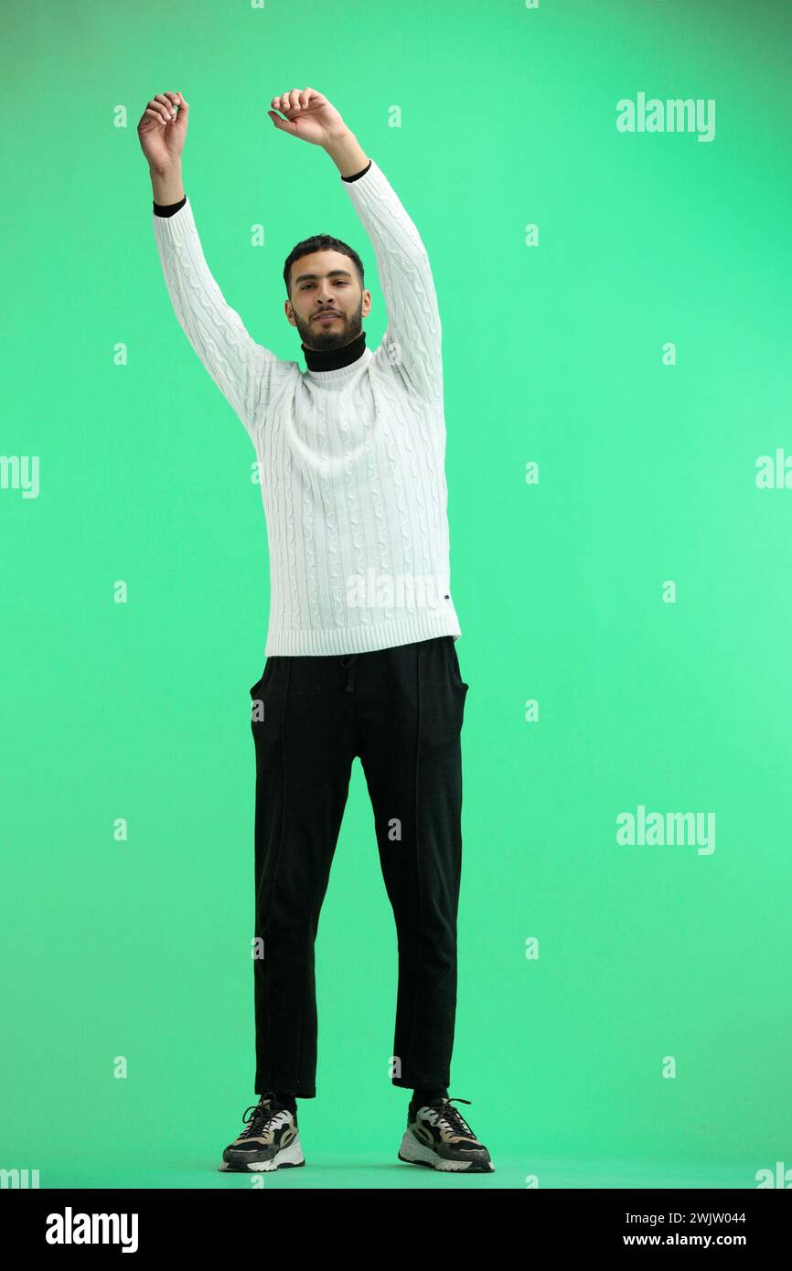 A man, full-length, on a green background, waving his arms Stock Photo ...