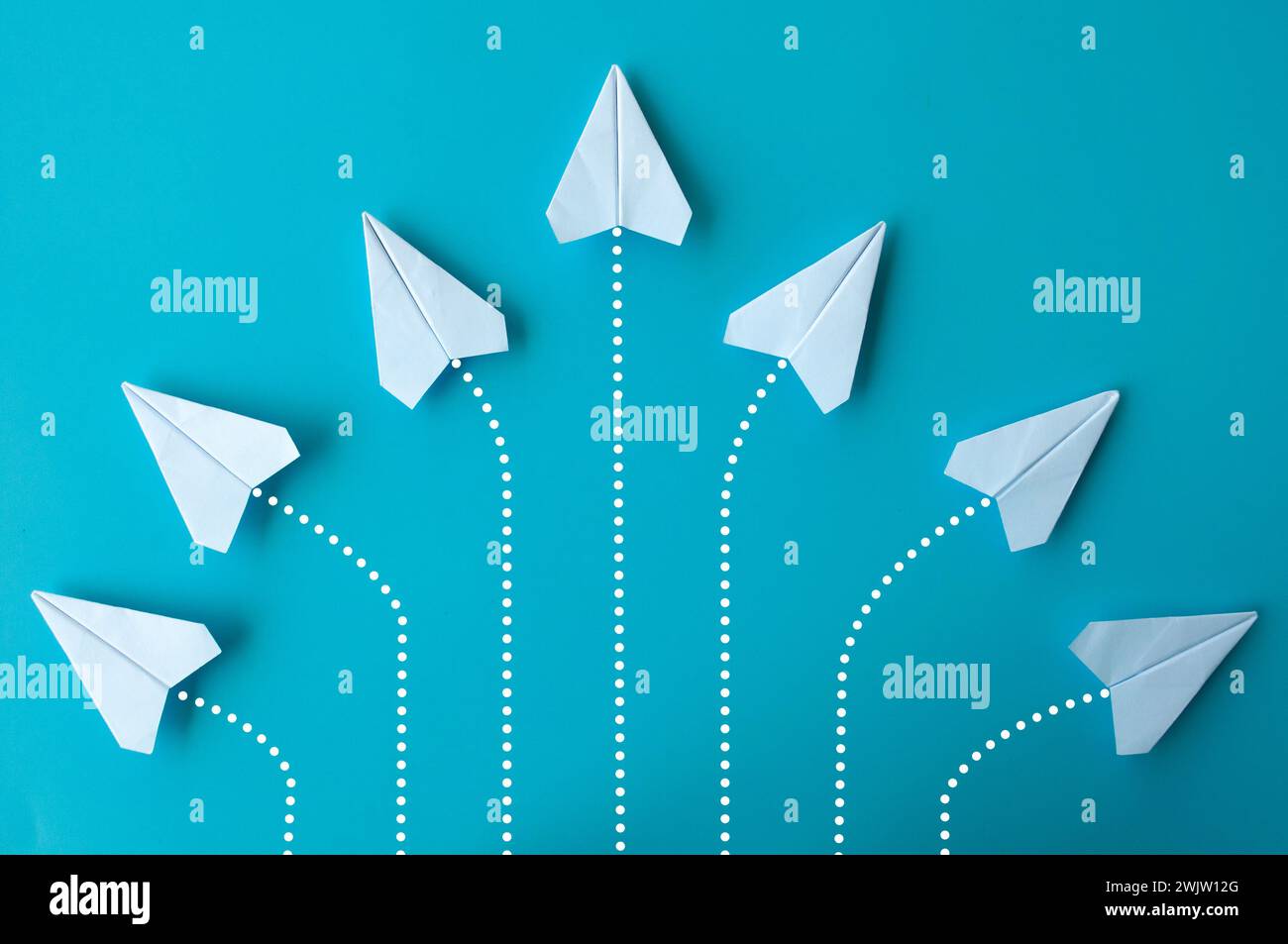 Top view of white paper airplanes origami flying at different direction ...
