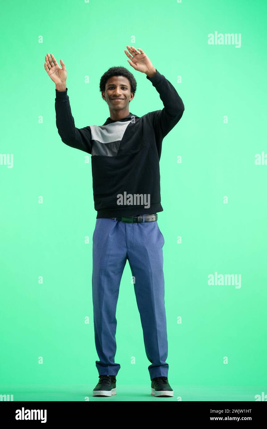 A man, full-length, on a green background, waving his arms Stock Photo ...