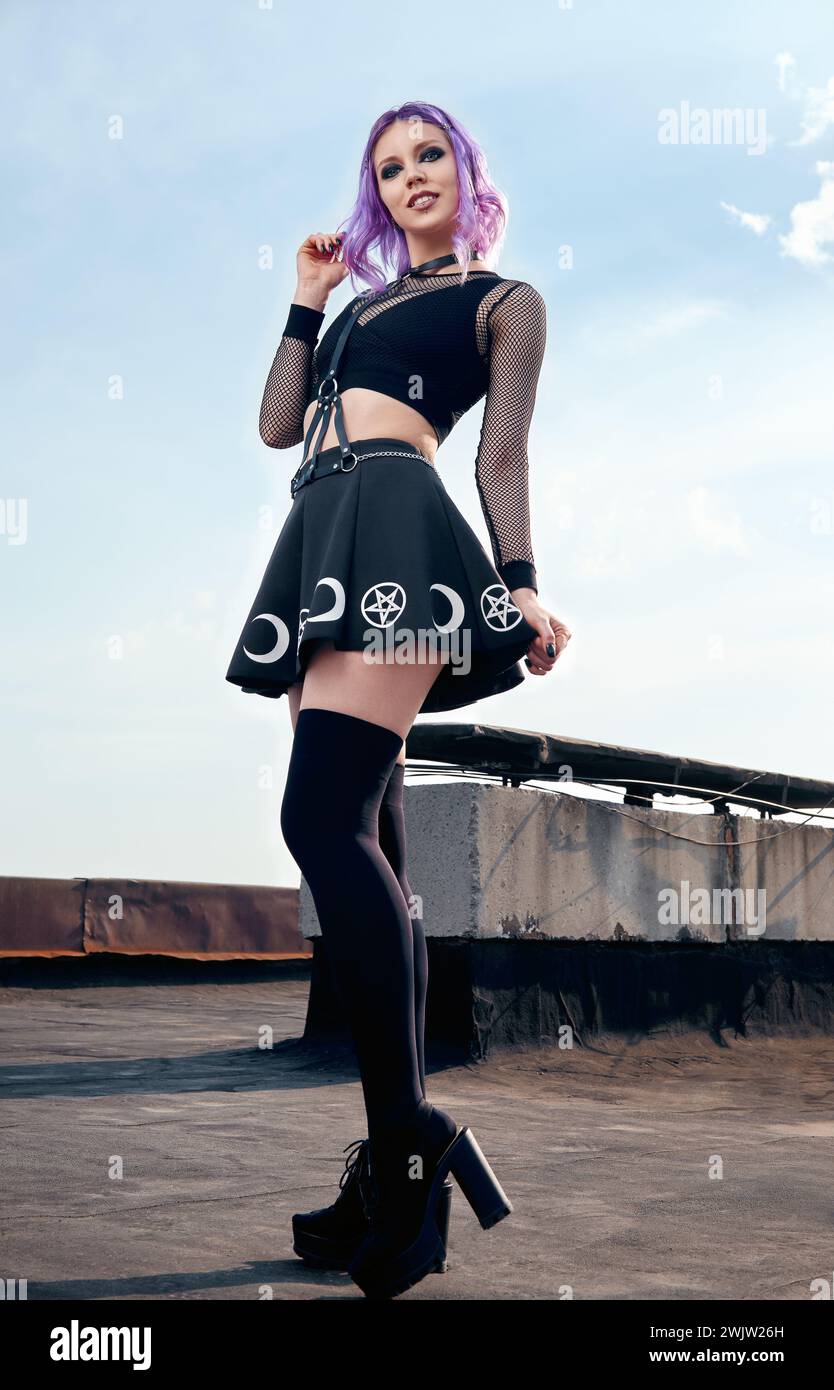 Portrait of cheerful smiling gothic girl on the roof. Pastel goth with ...