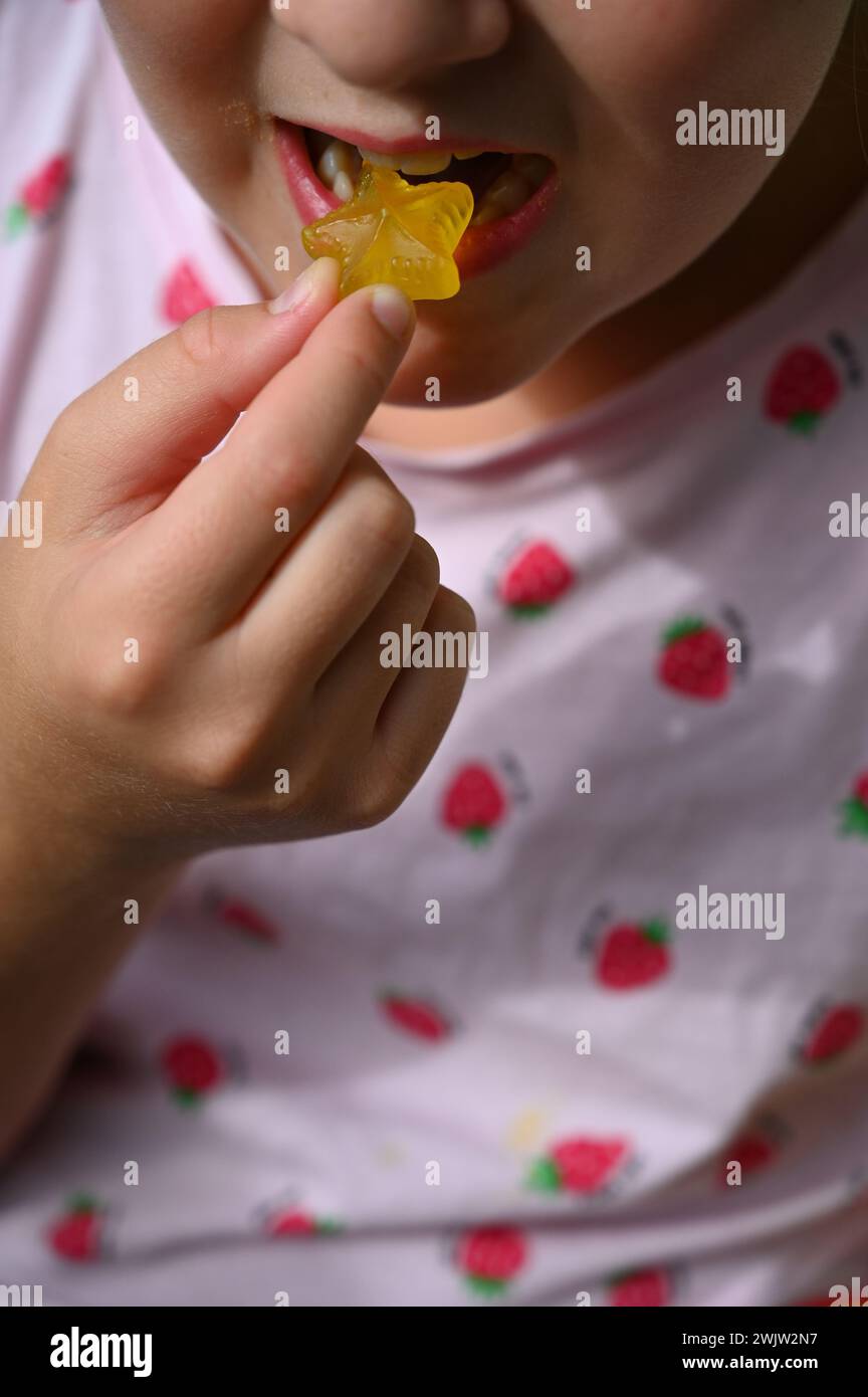 Young girl - child eating candy and sweets. Detail of face and mouth ...