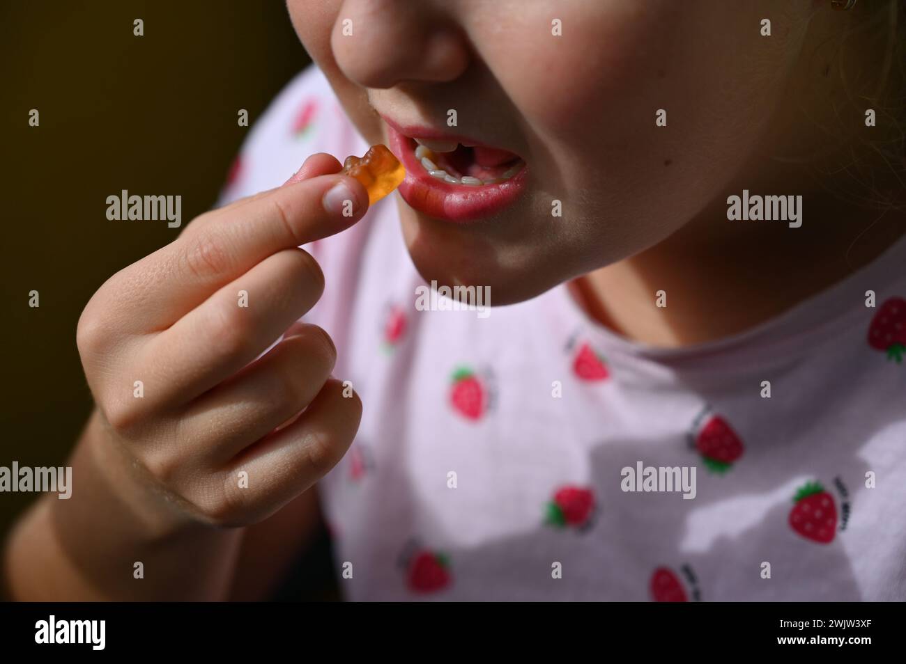 Young girl - child eating candy and sweets. Detail of face and mouth ...