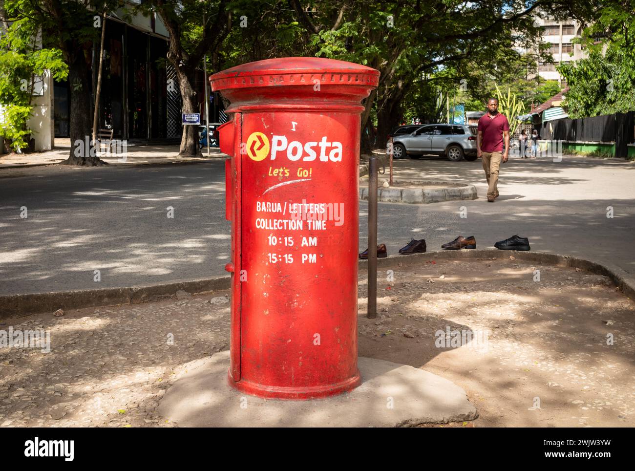 Shoes on the kerb next to a British colonial style red pillar box, or ...