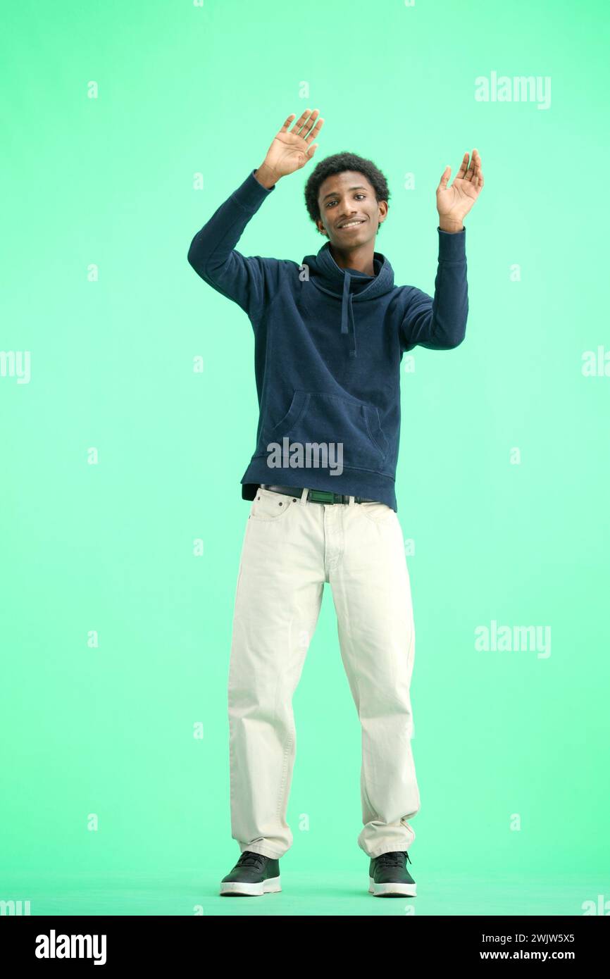 A man, full-length, on a green background, waving his arms Stock Photo ...