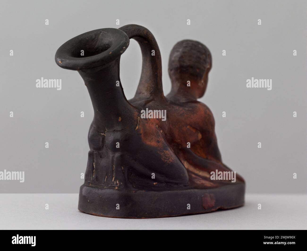 Guttus in the shape of an African child crouching. Tour and molded ...