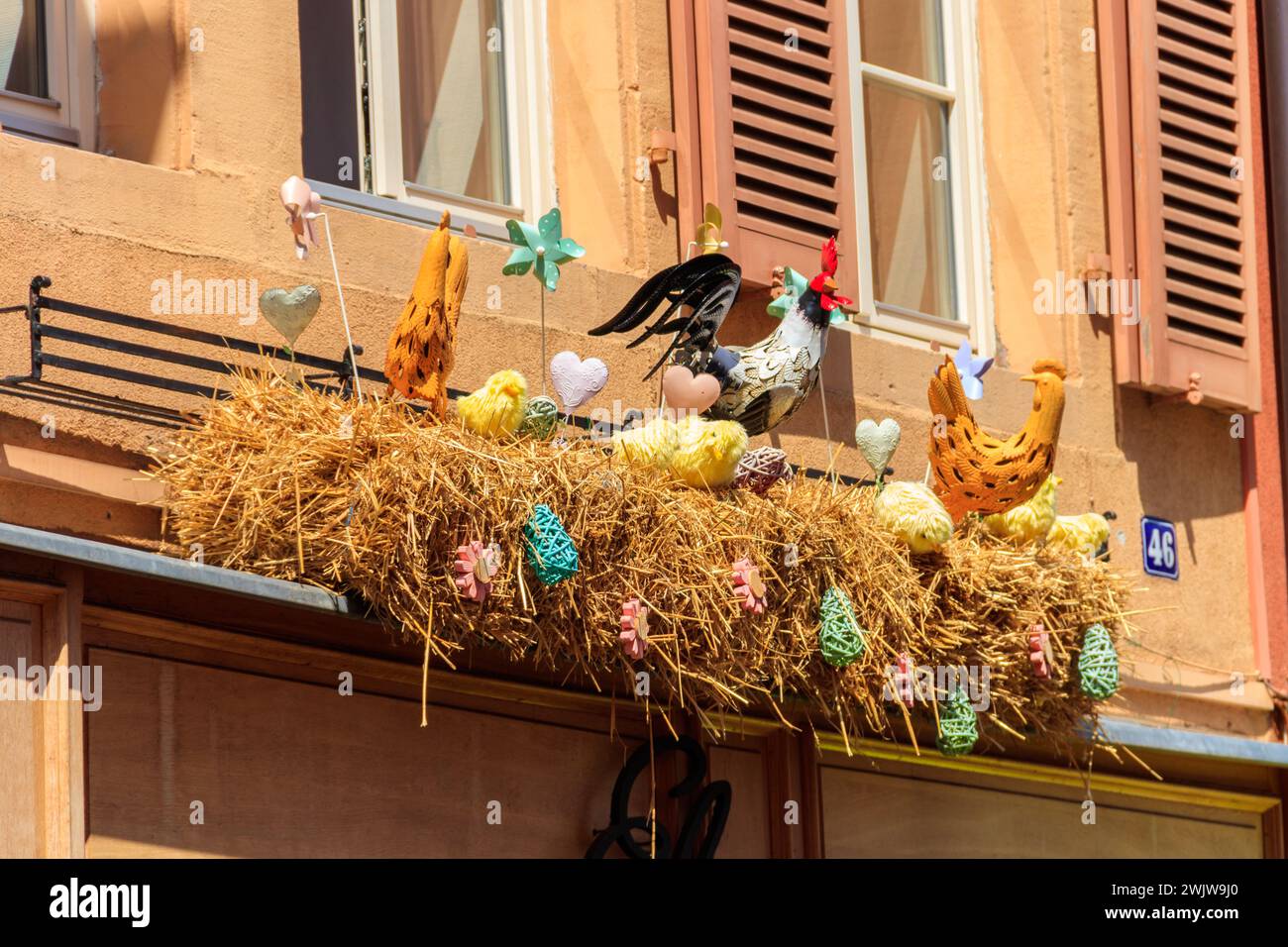 Easter decoration with rooster, hens and chickens in a nest on a house ...
