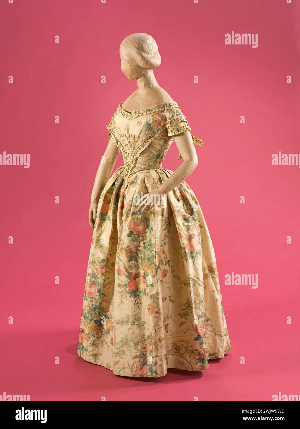 Ball gown. Golden yellow silk with printing on chain of large bouquets of pink flowers and ...