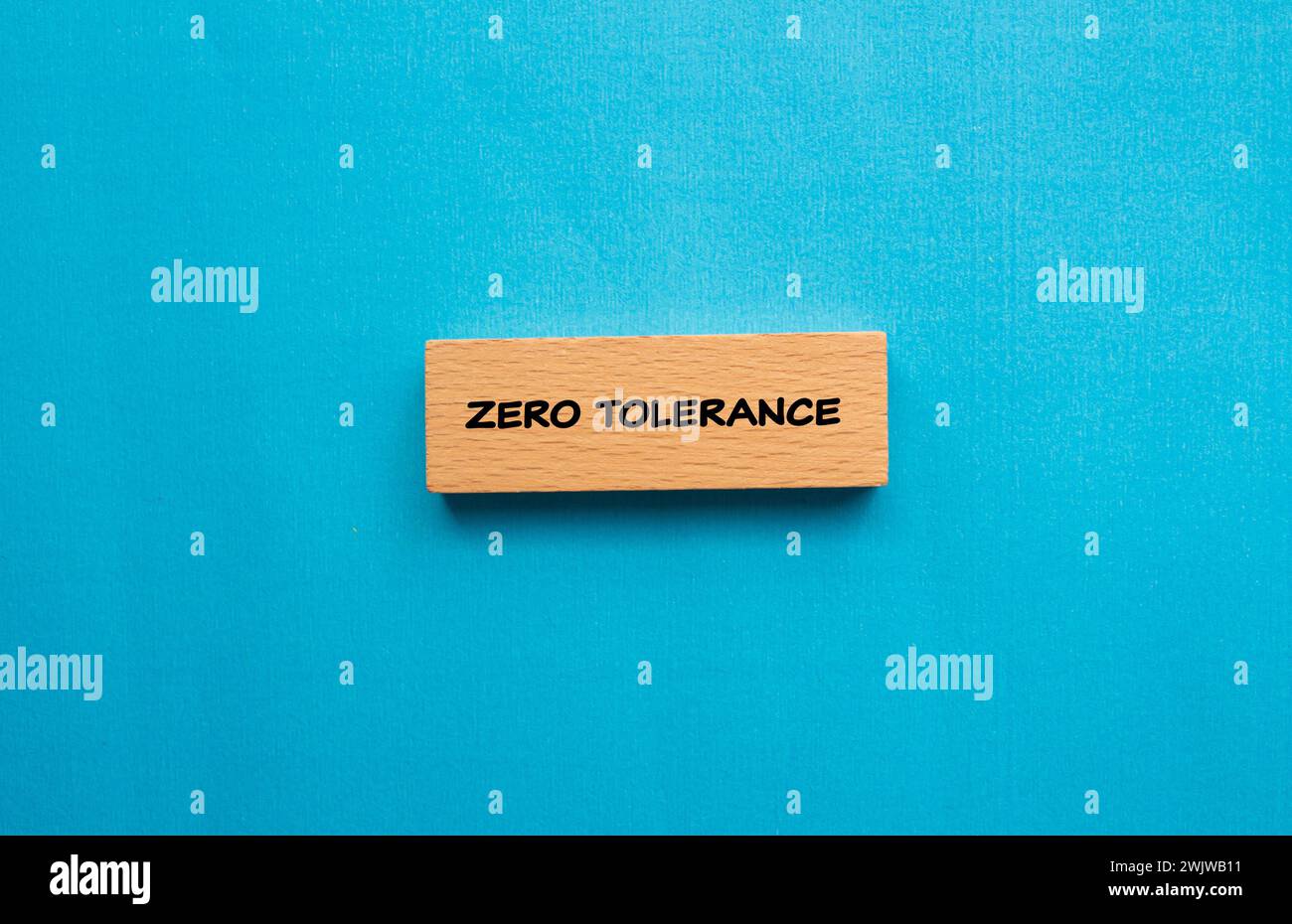 Zero tolerance words written on wooden block with blue background ...