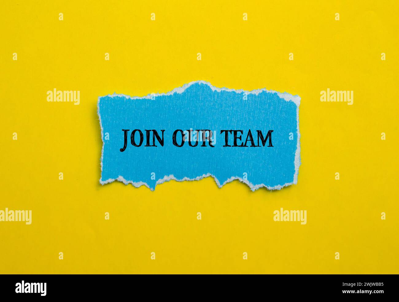 Join our team words written on blue torn paper piece with yellow ...