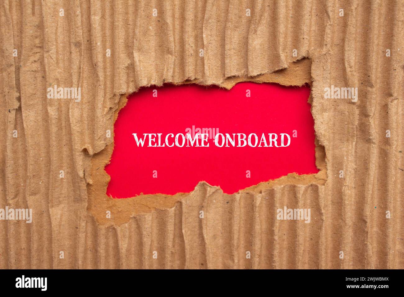 Welcome onboard words written on torn cardboard paper with red ...