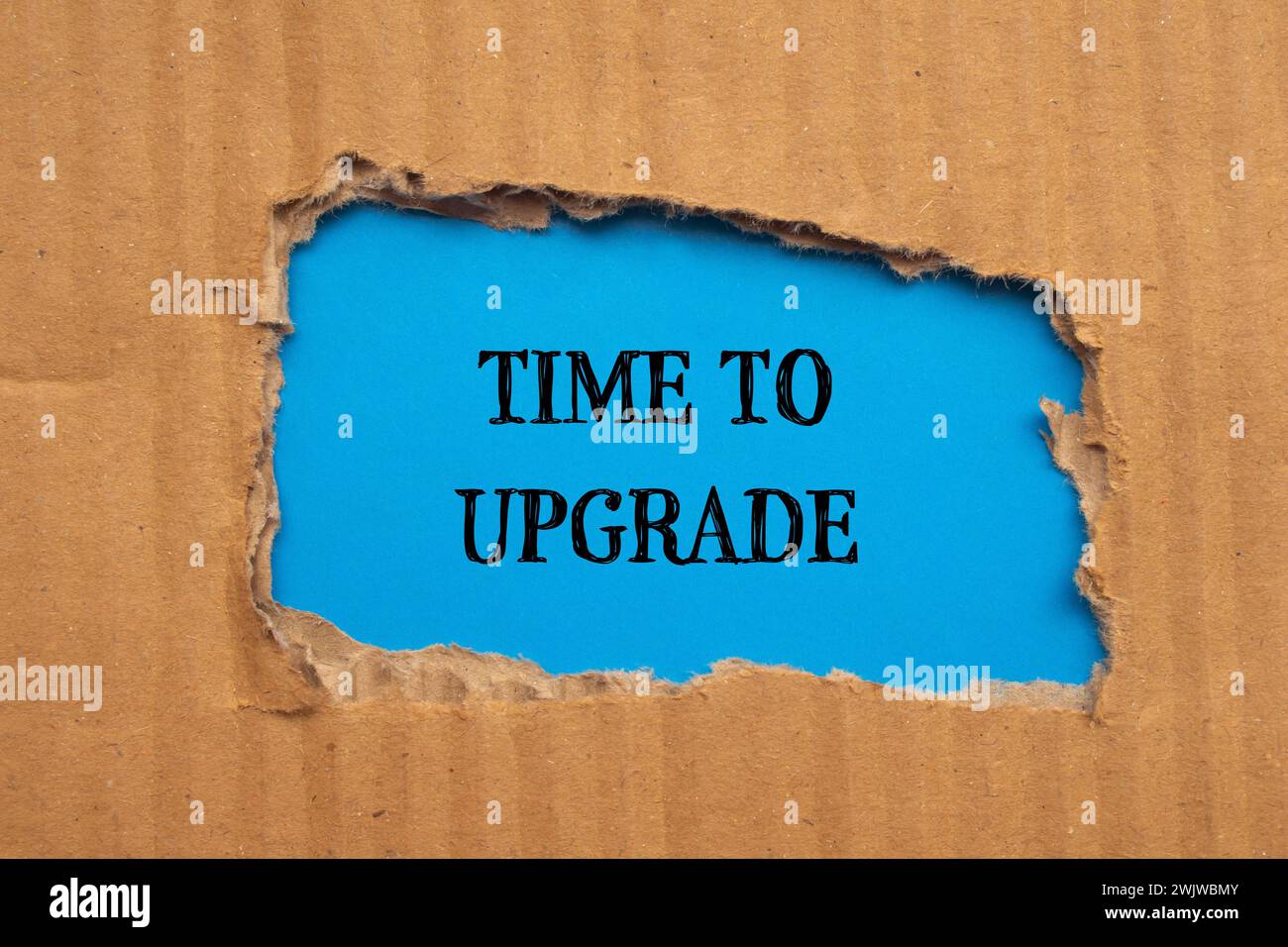 Time to upgrade words written on torn cardboard paper with blue ...