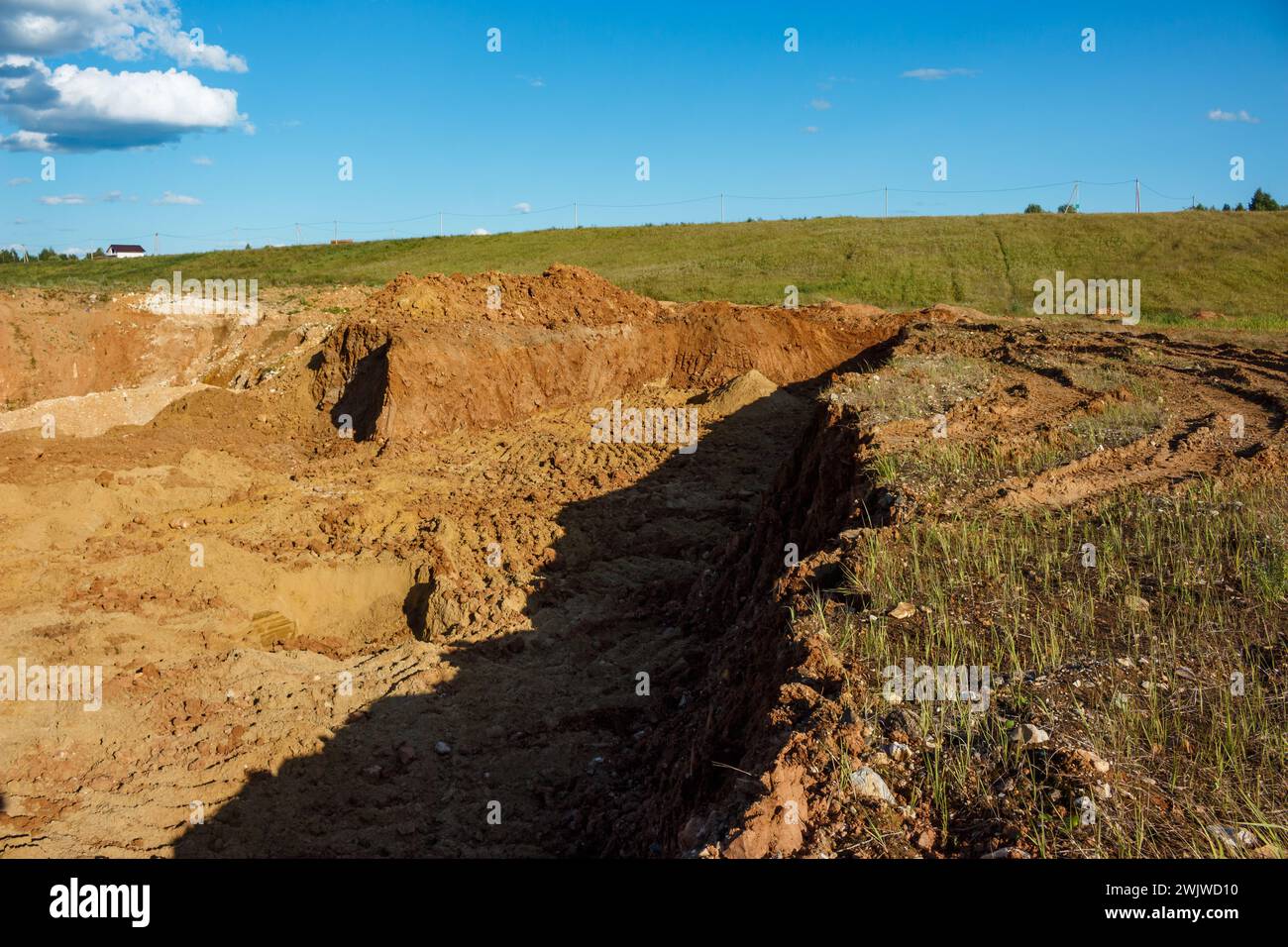 A pit dug in the ground to layers of sand using heavy equipment Stock ...