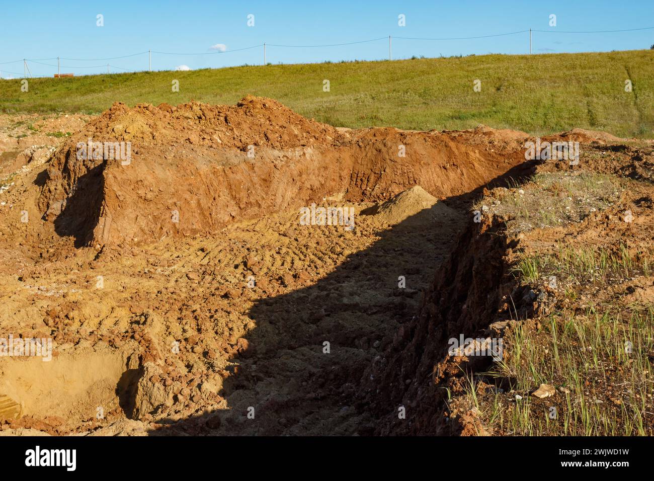 A pit dug in the ground to layers of sand using heavy equipment Stock ...