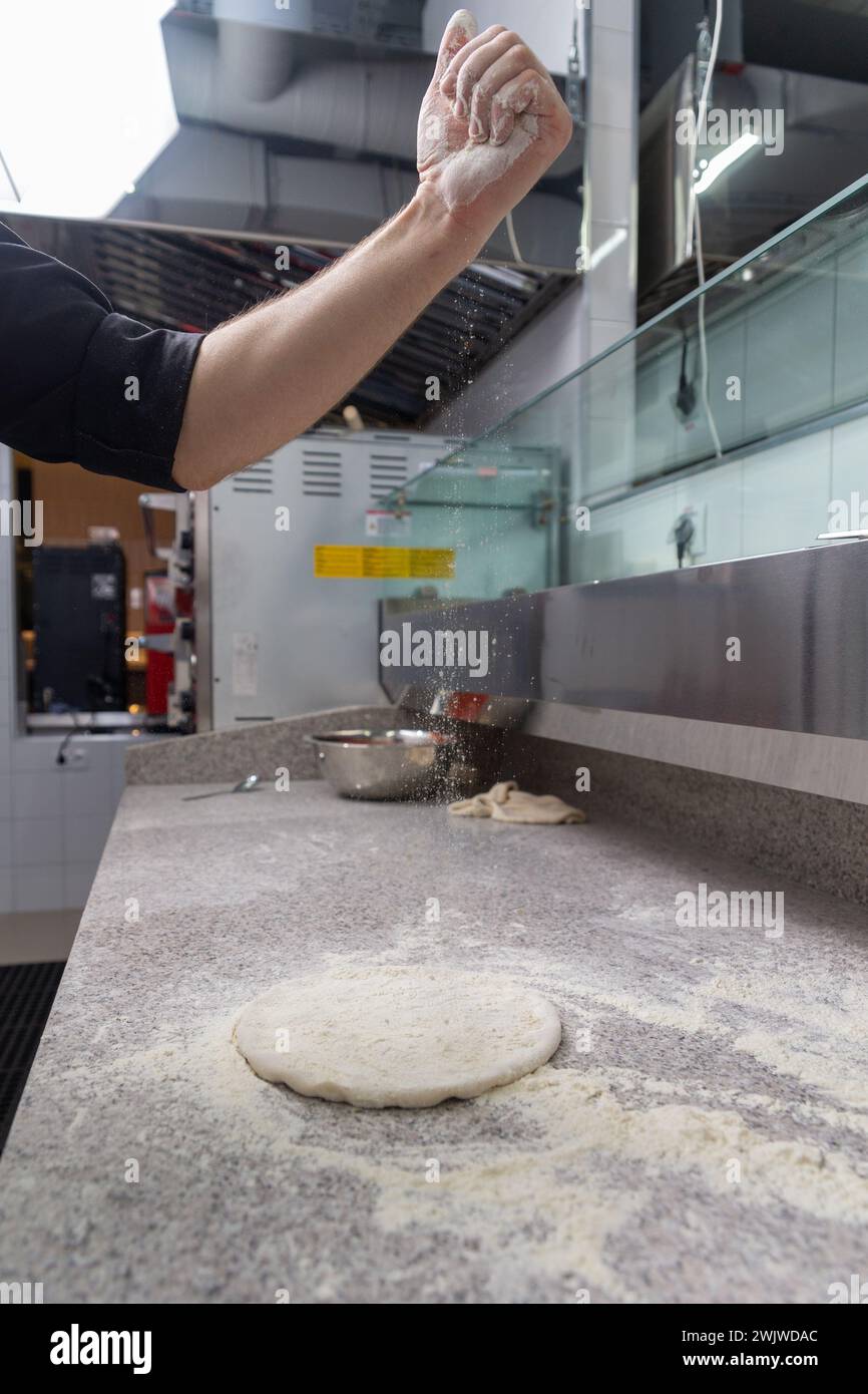 Chef prepares the dough with flour. Male sprinkling flour over dough on ...
