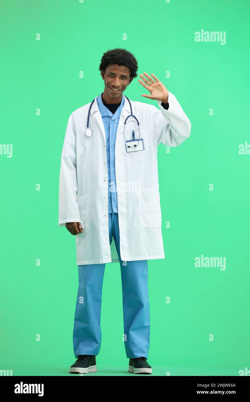 The doctor, in full height, on a green background, waving his hand ...