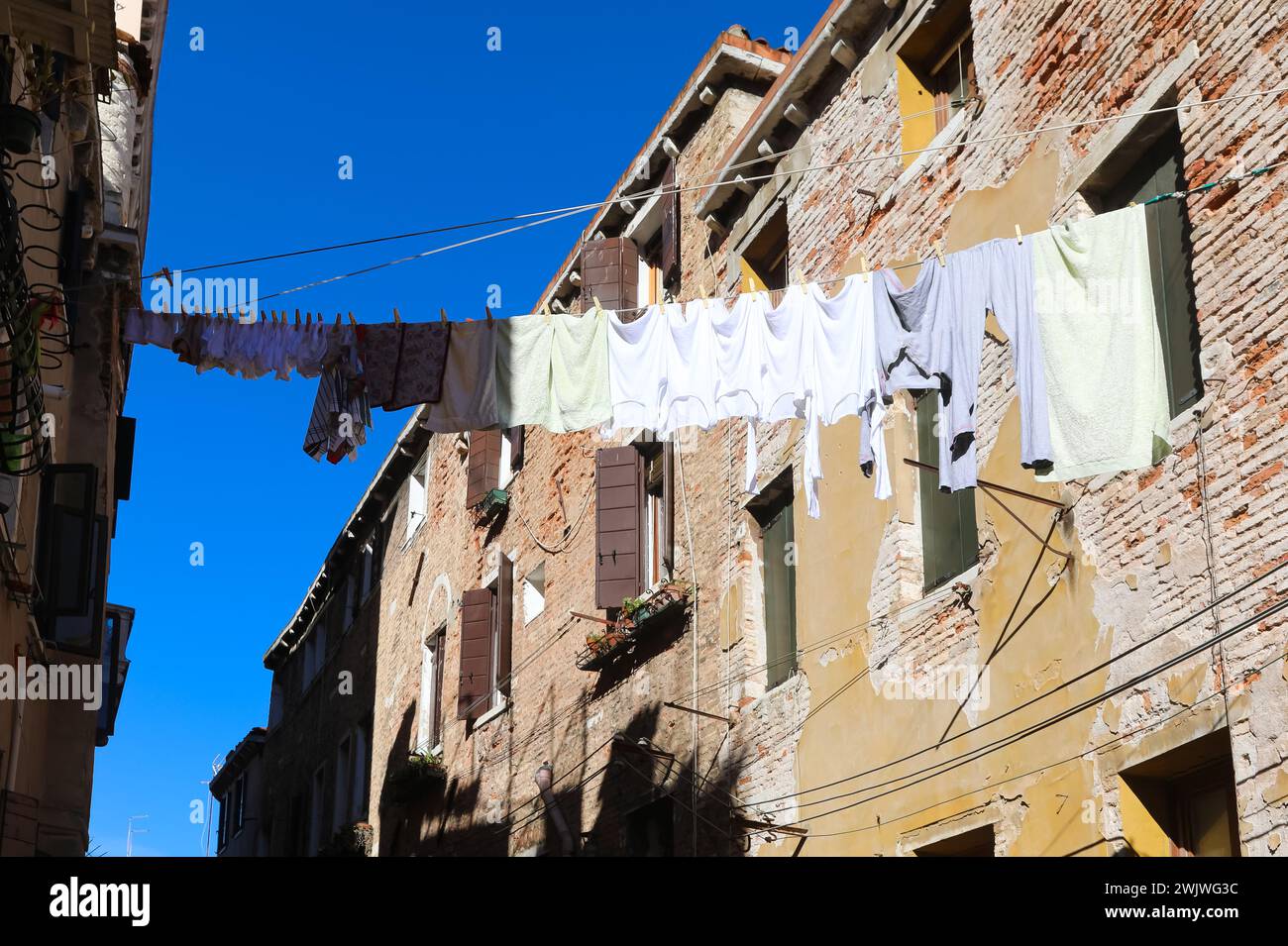 many clothes hanging and linen drying in the sun in the narrow alley ...