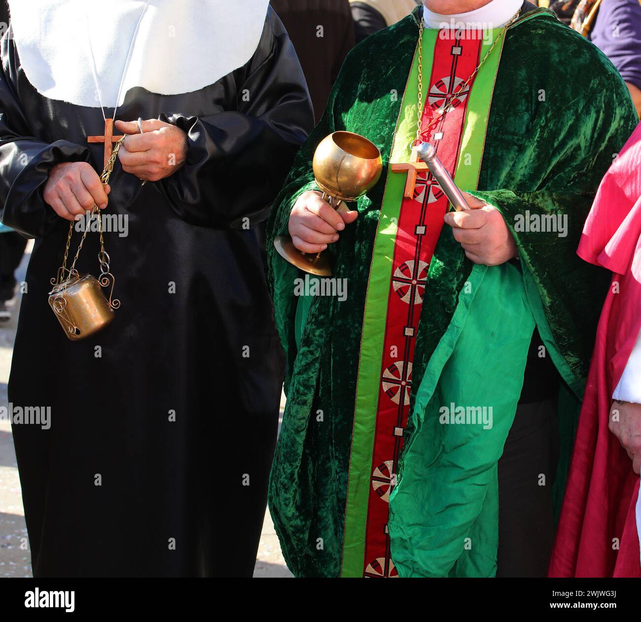 priest with cassock and aspergillum while performing the blessing with ...