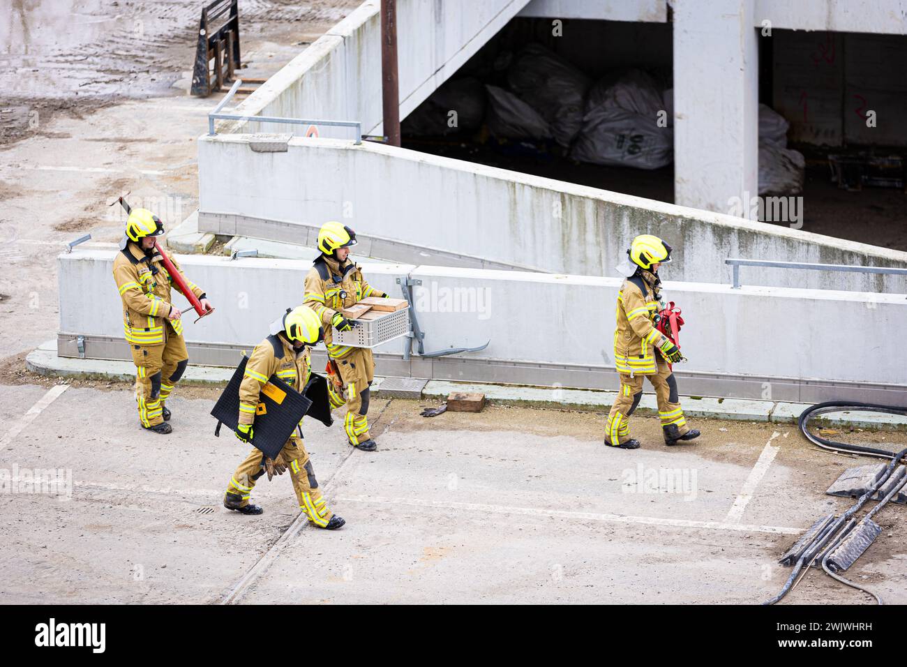 Hanover, Germany. 17th Feb, 2024. Firefighters walk across the site of ...