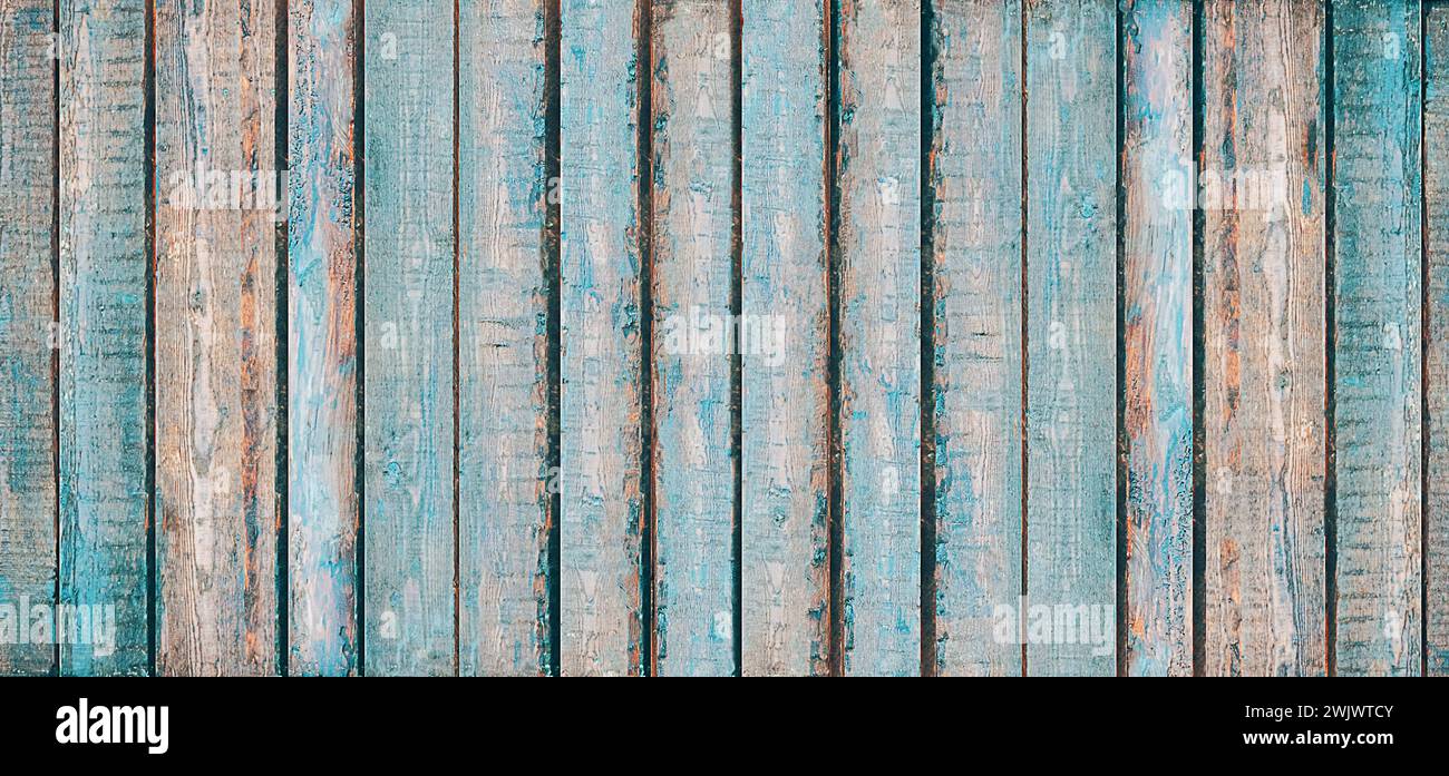 Faded texture of a wooden surface painted in blue. Peeling blue paint ...