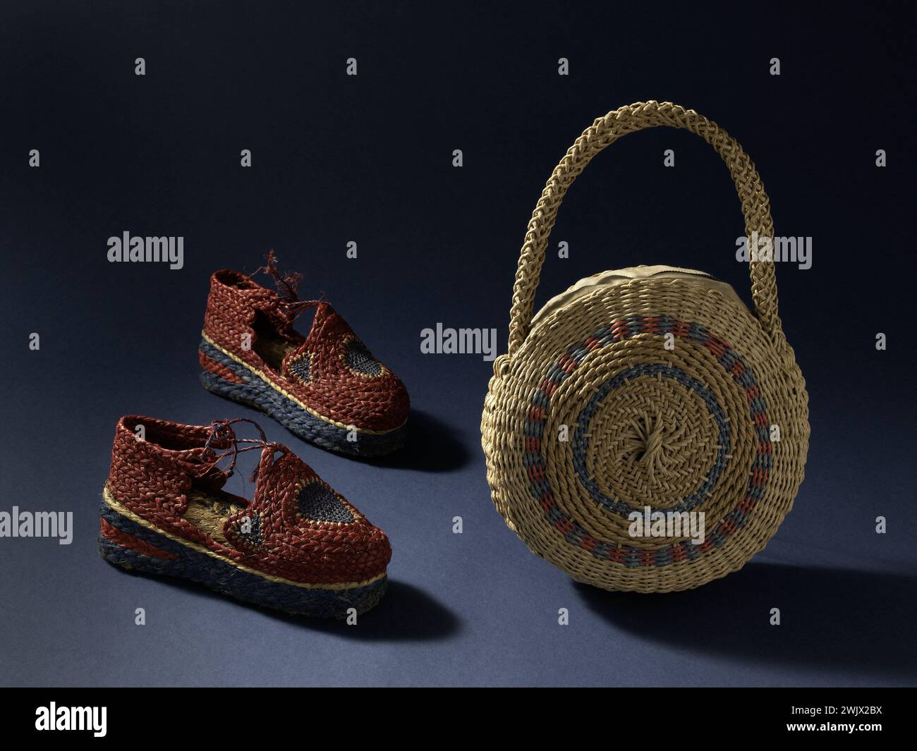 Pair of milestones in natural, blue and red raffia; blue and red ...