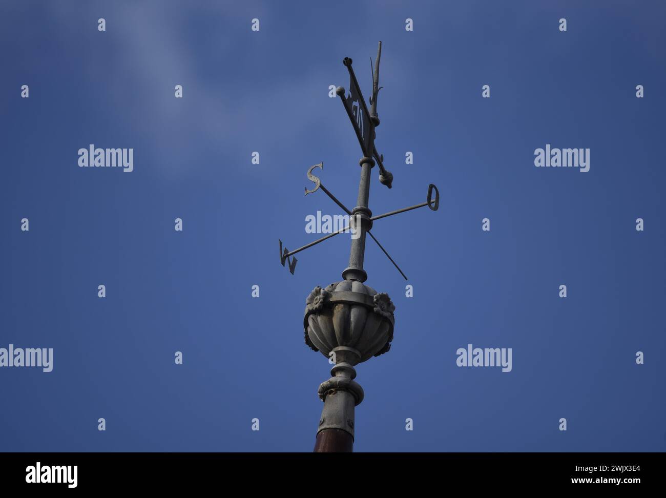 Vintage metal compass on the rooftop of a Gothic style building in the ...