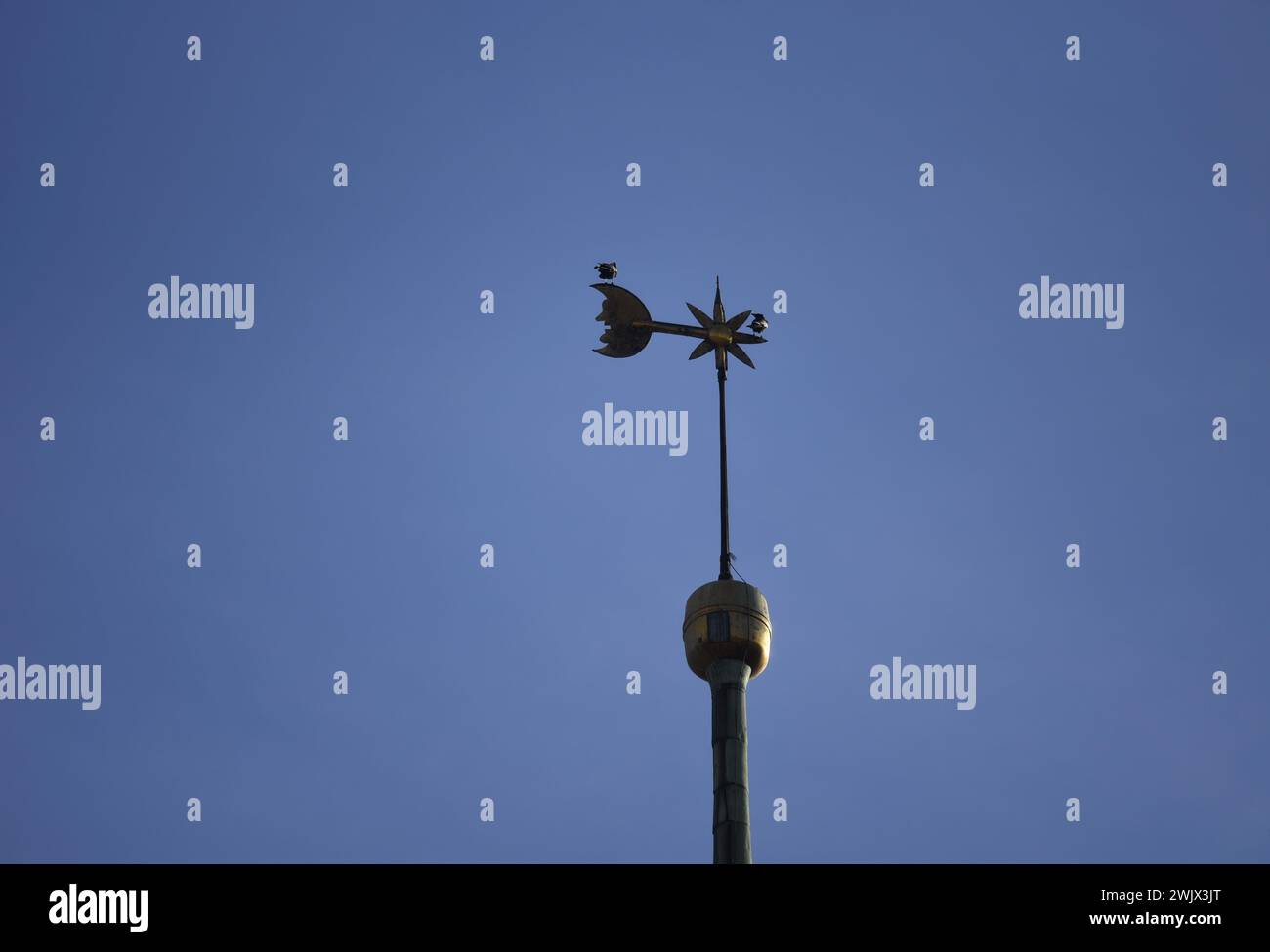 Antique compass rooftop symbols against a blue sky n Turckheim, Alsace ...