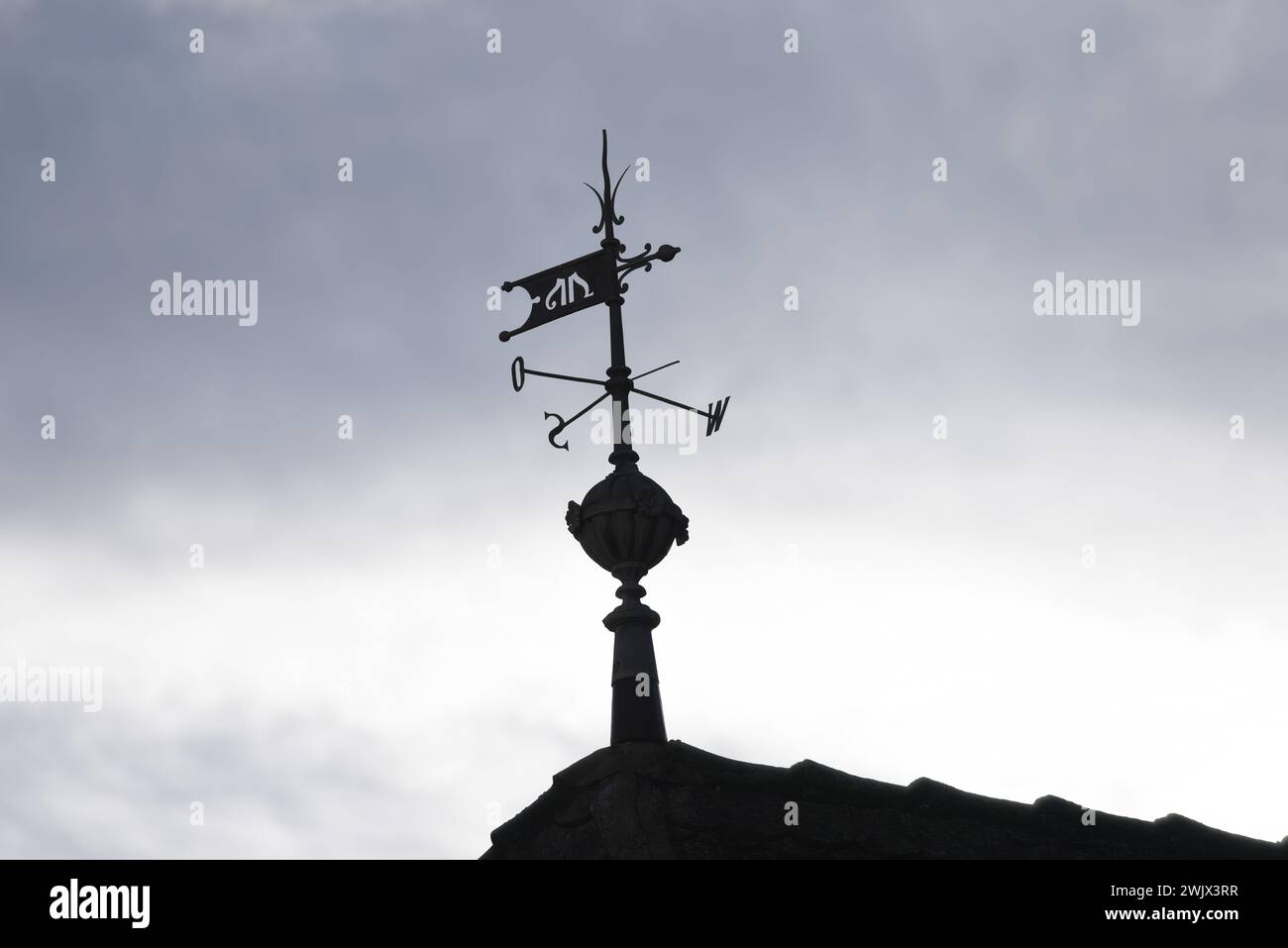 Vintage metal compass on the rooftop of a Gothic style building in the ...