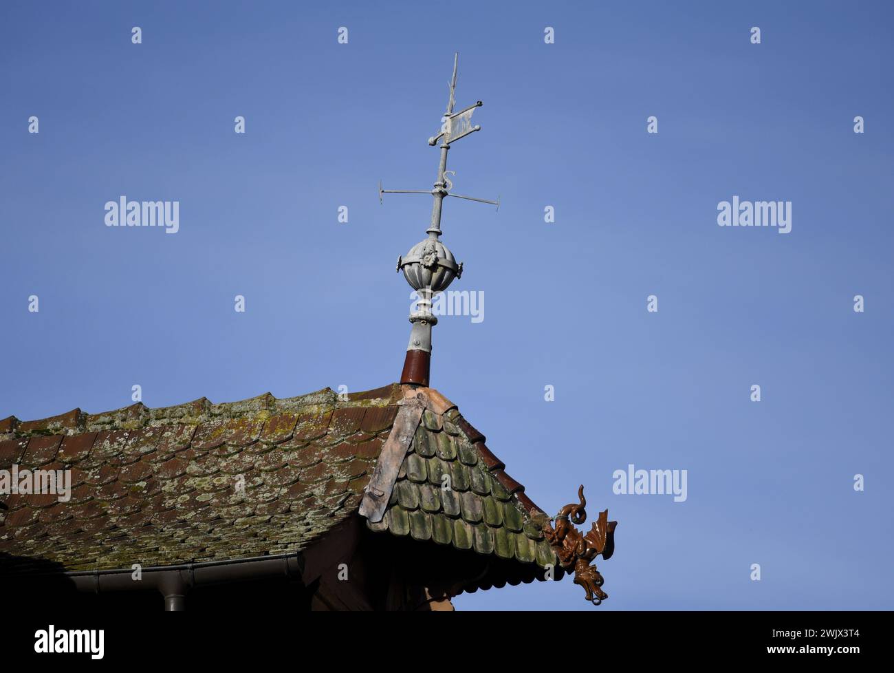 Vintage metal compass on the rooftop of a Gothic style building in the ...