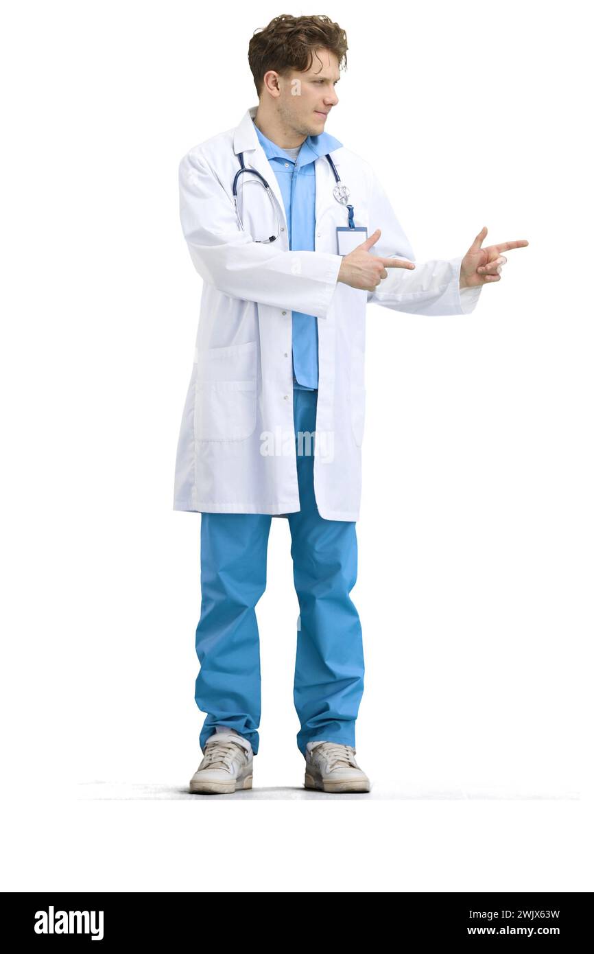 The doctor, in full height, on a white background, points to the side ...