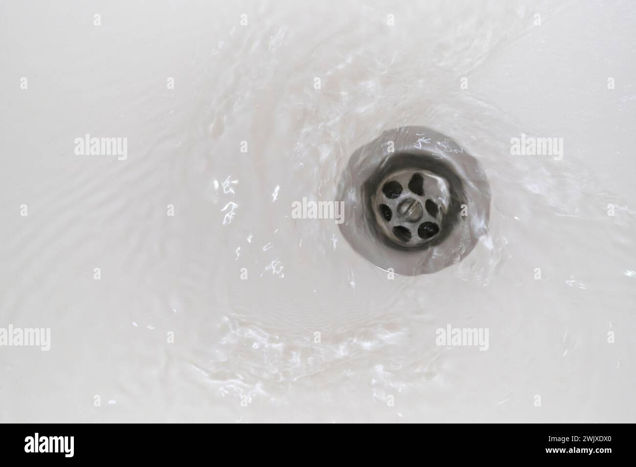 Swirl of water flows down the drain in the bathroom Stock Photo - Alamy