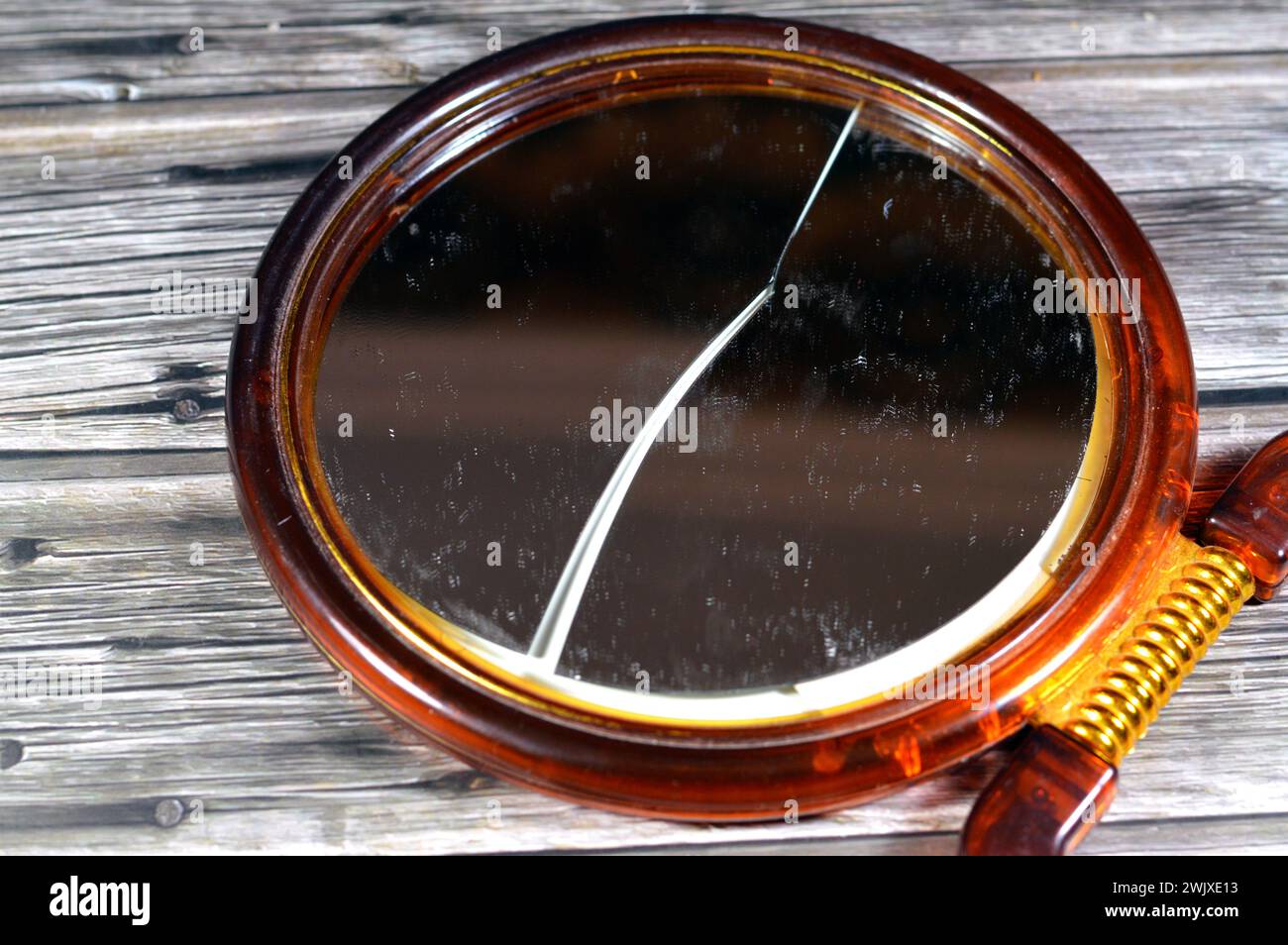 Broken hand mirror, cracked, crushed damaged mirror glass, a mirror is ...