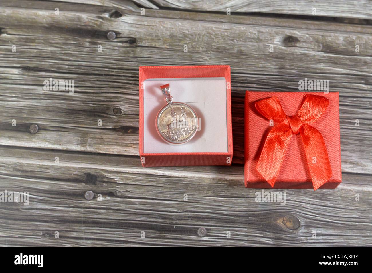 A red gift small decorated box with an Islamic pound coin of pure ...