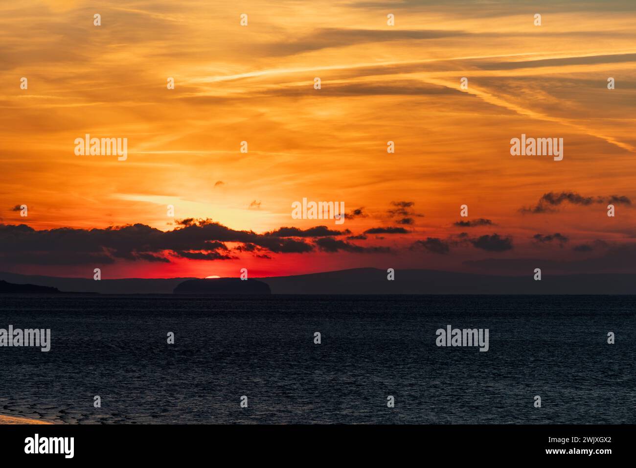 The setting sun lighting up the horizon Stock Photo - Alamy
