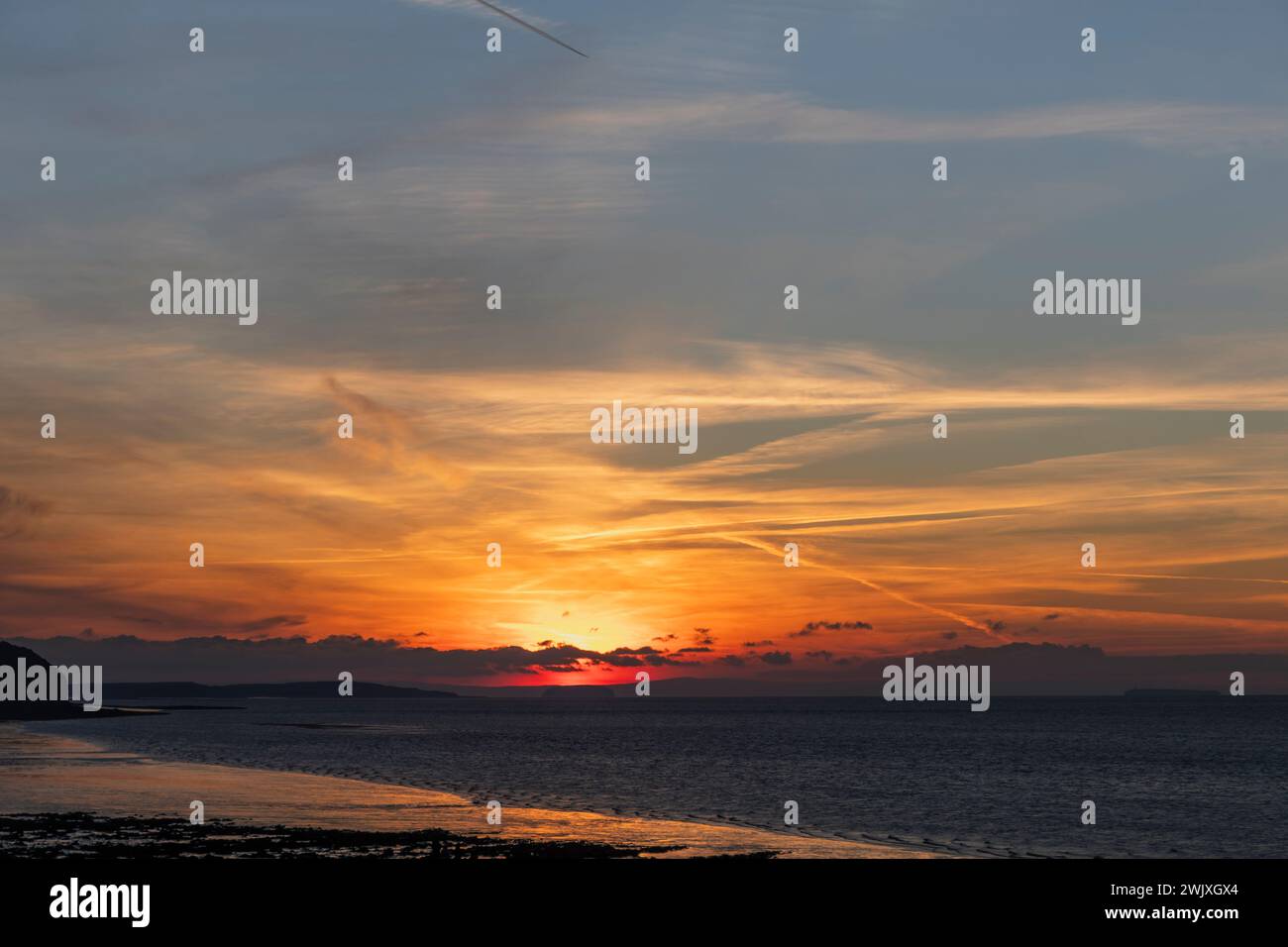 The setting sun lighting up the horizon Stock Photo - Alamy