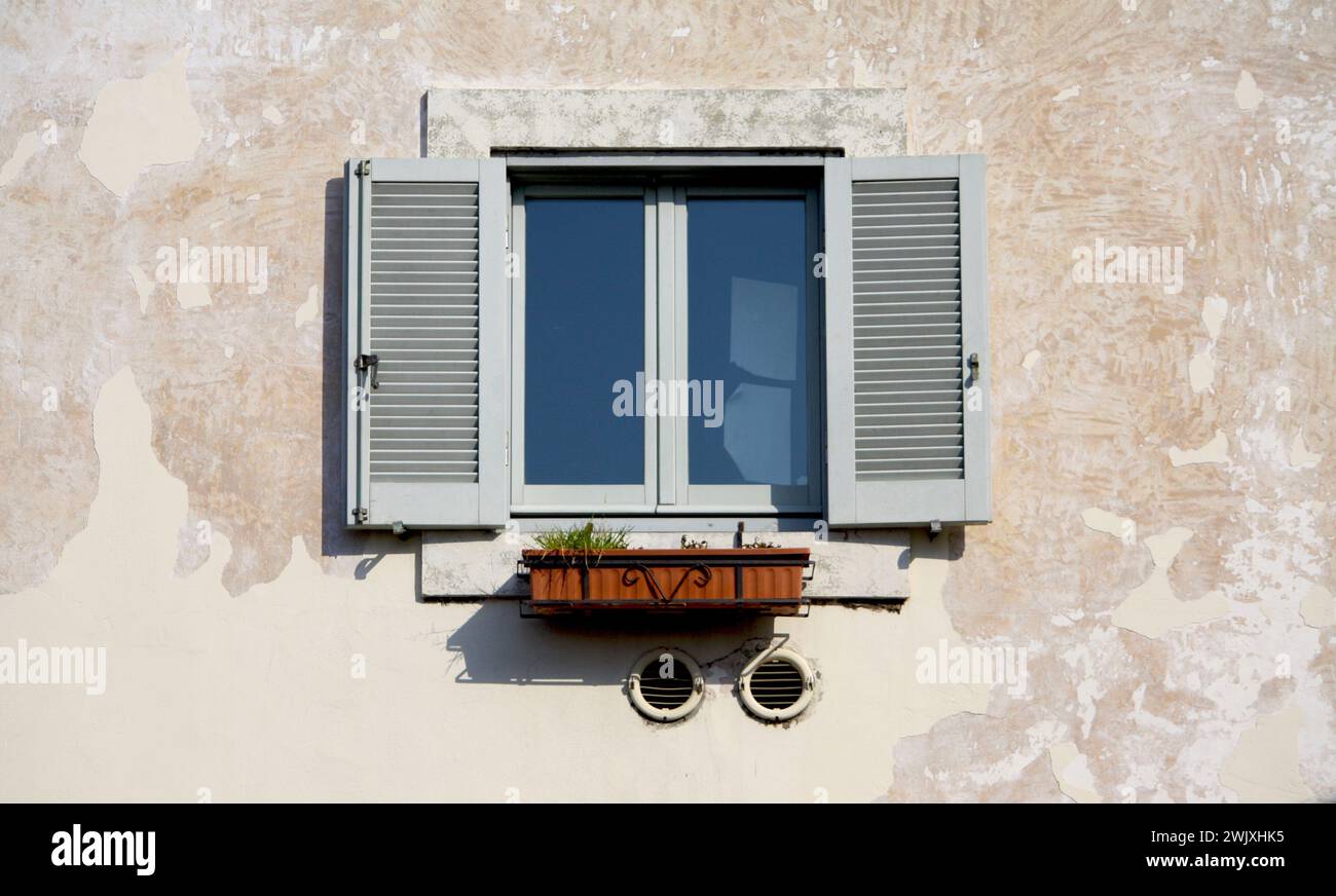 modern window set in a wall with unrefined plaster, showcasing a blend ...
