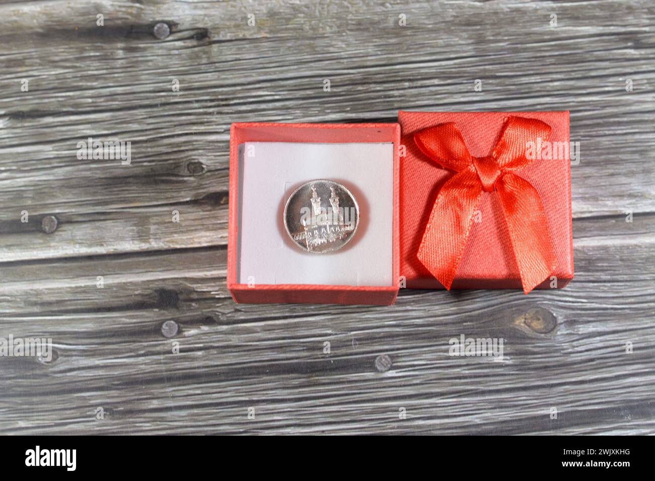 A red gift small decorated box with an Islamic pound coin of pure ...