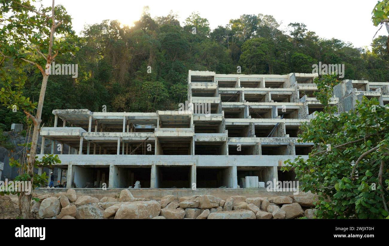 Unfinished concrete building structure amidst tropical forest Stock ...